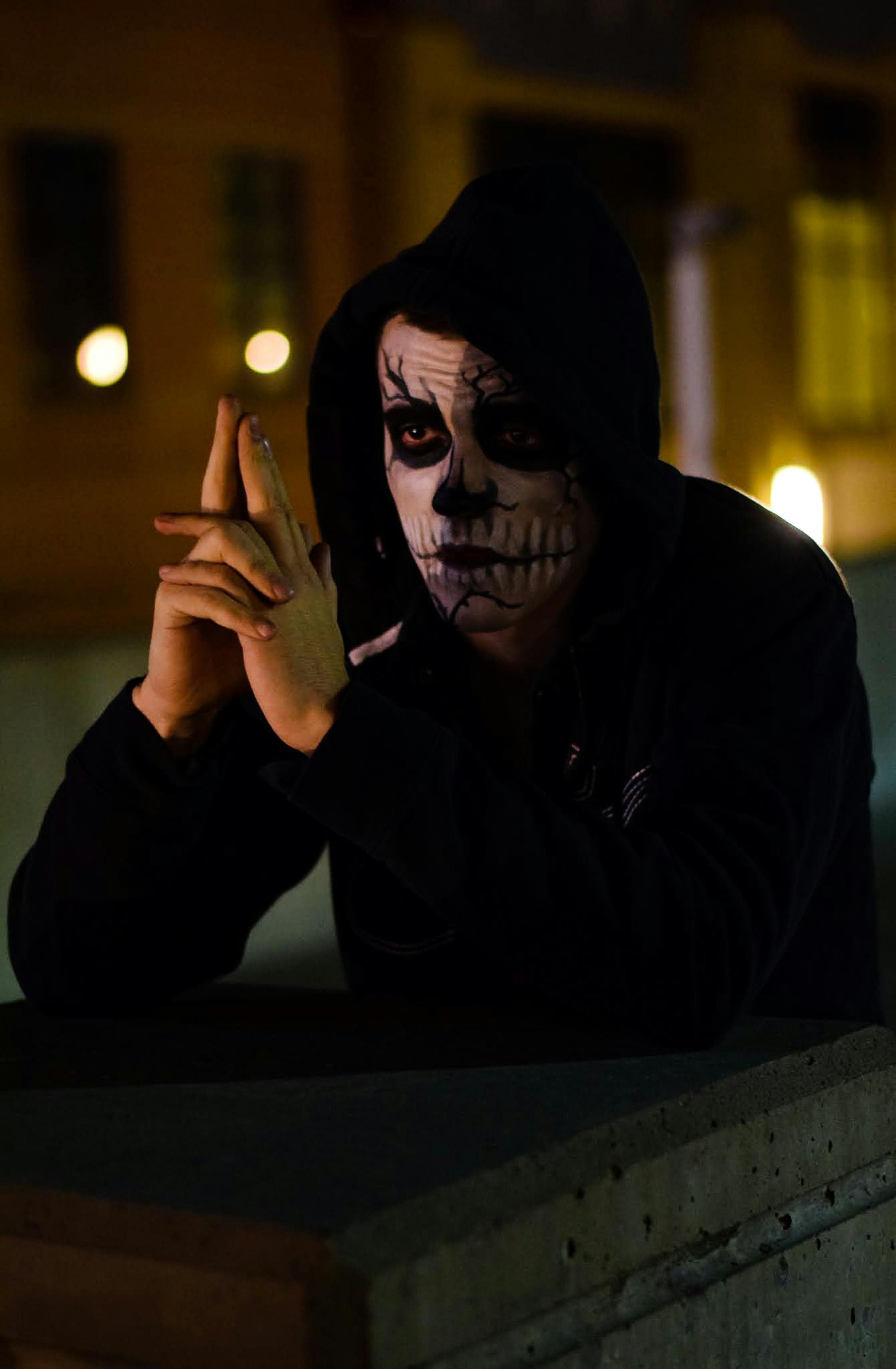 A Man with Creepy Face Paint Wearing Black Hoodie while Looking Afar ...