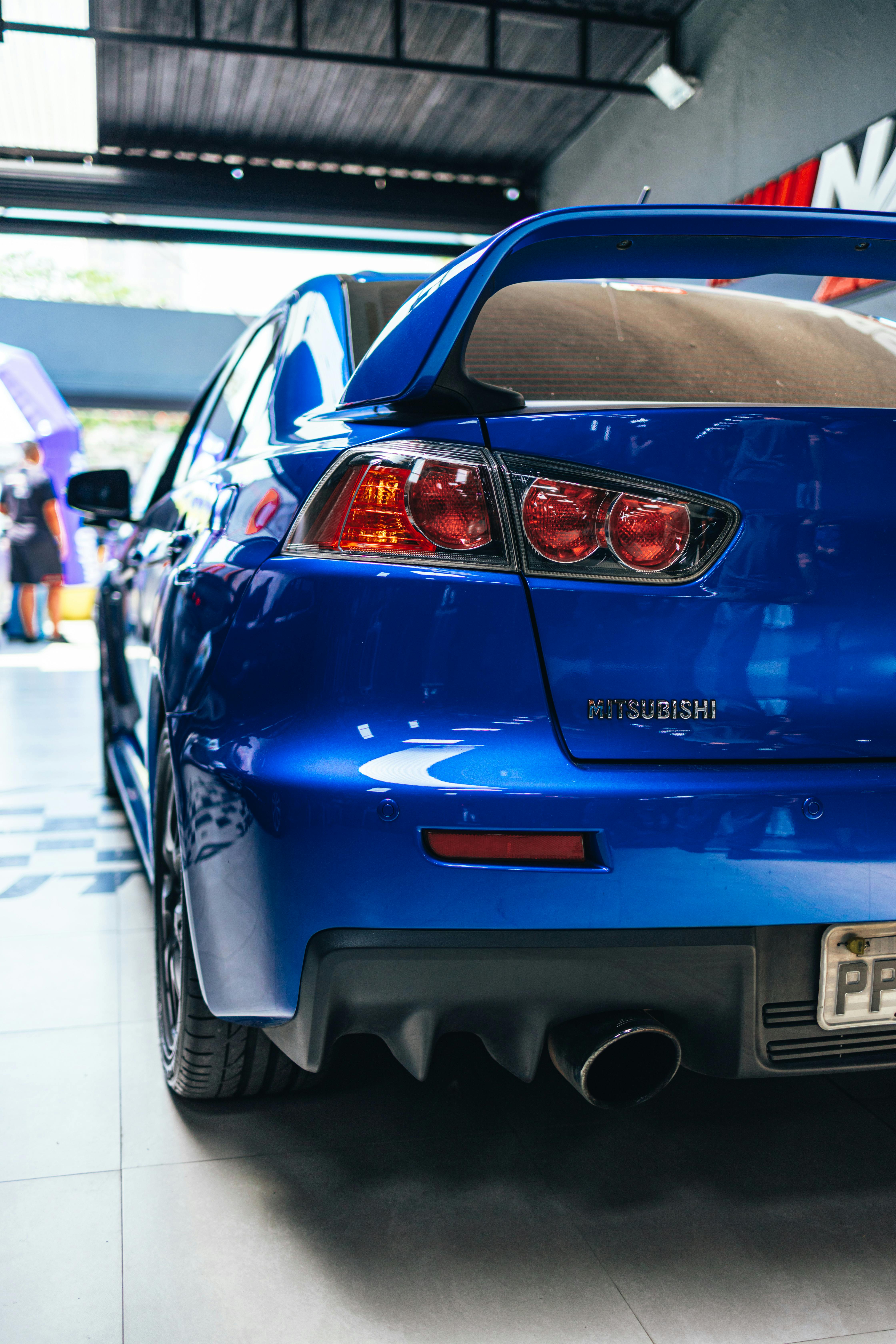 A Shiny Blue Sports Car Parked on Concrete Floor · Free Stock Photo