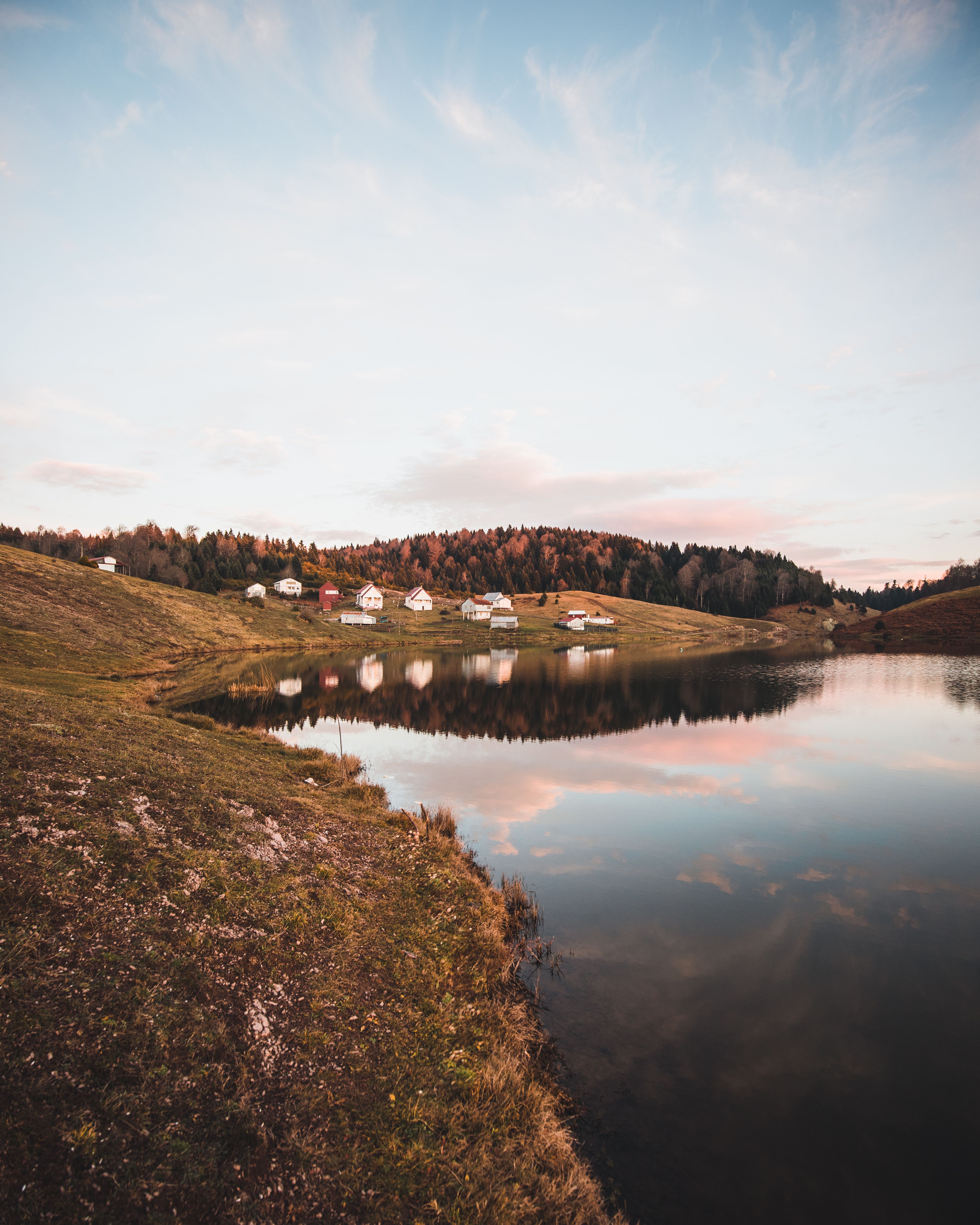 Green Grass Field Near Lake Under Blue Sky · Free Stock Photo