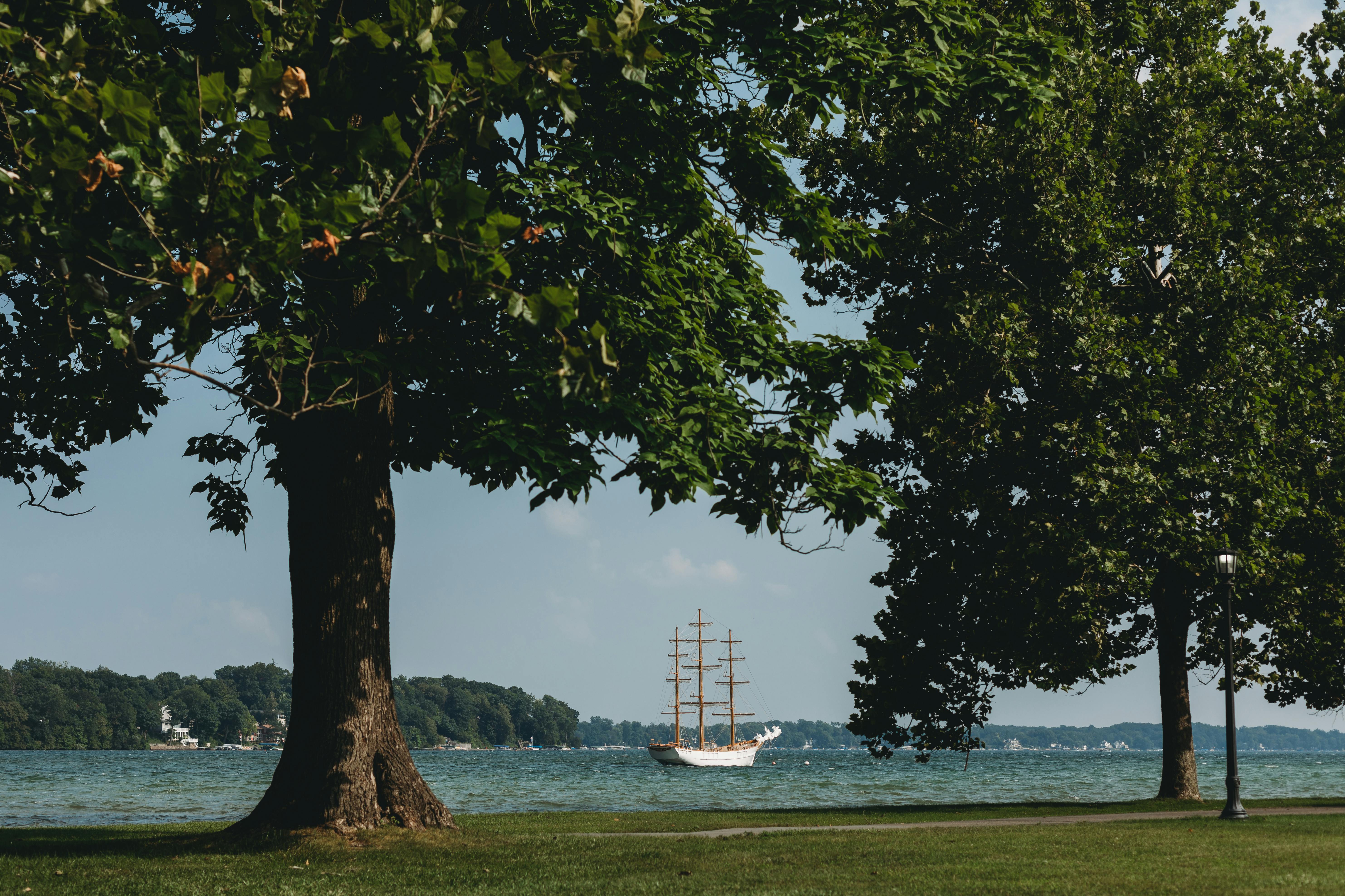 Ship with Masts Sailing behind Trees · Free Stock Photo