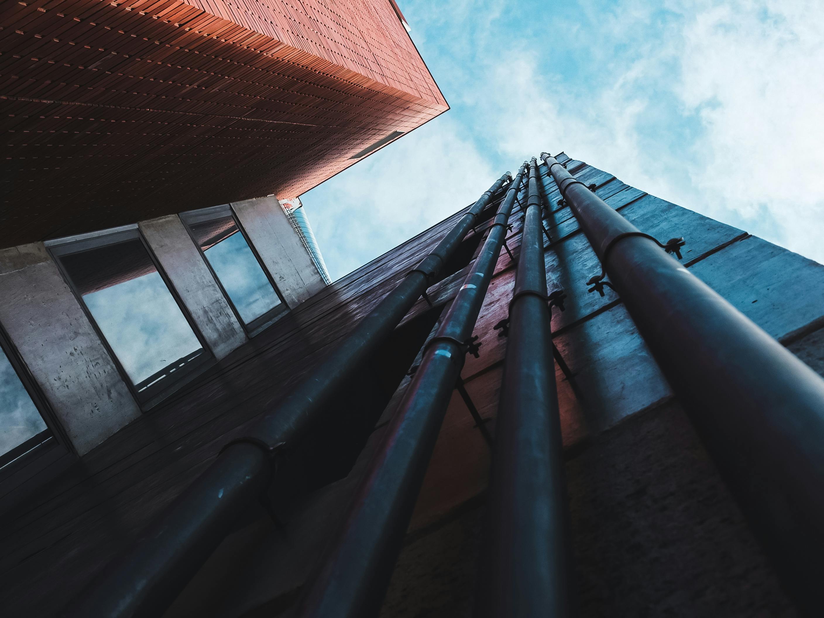 A Low Angle Shot of a Building with Pipes · Free Stock Photo