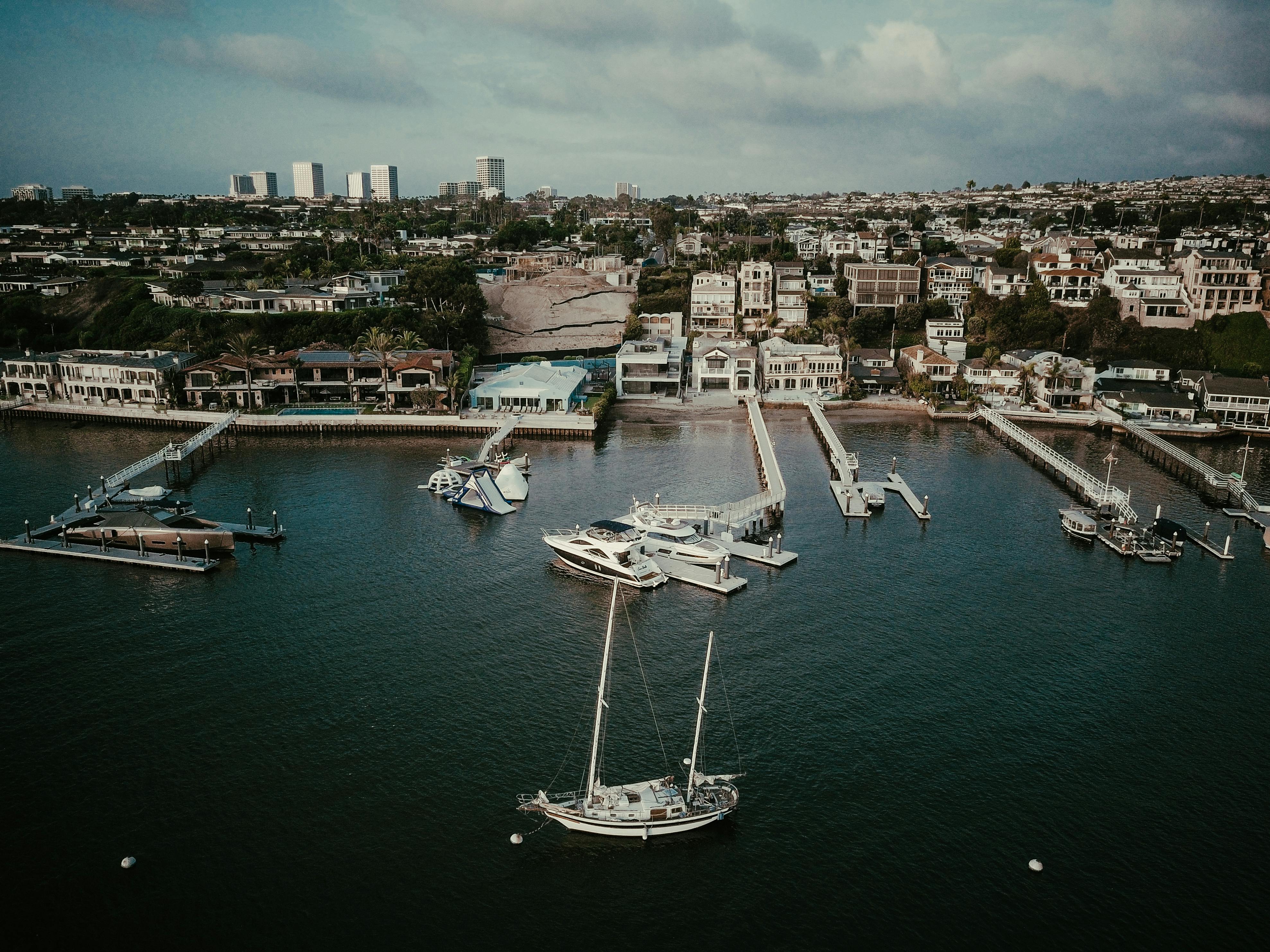 White Boast on Body of Water Near City Buildings · Free Stock Photo
