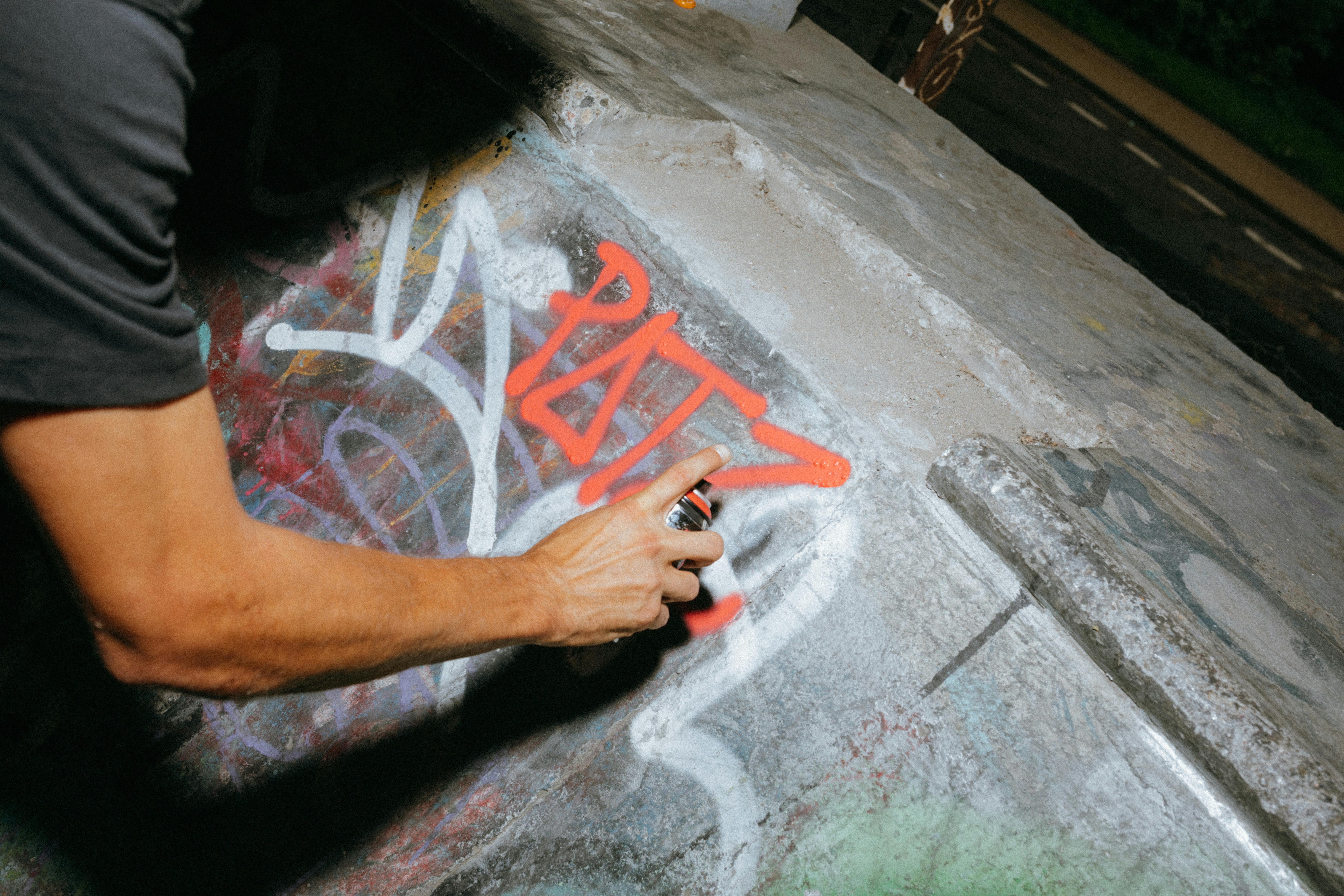 Man painting graffiti on wall · Free Stock Photo