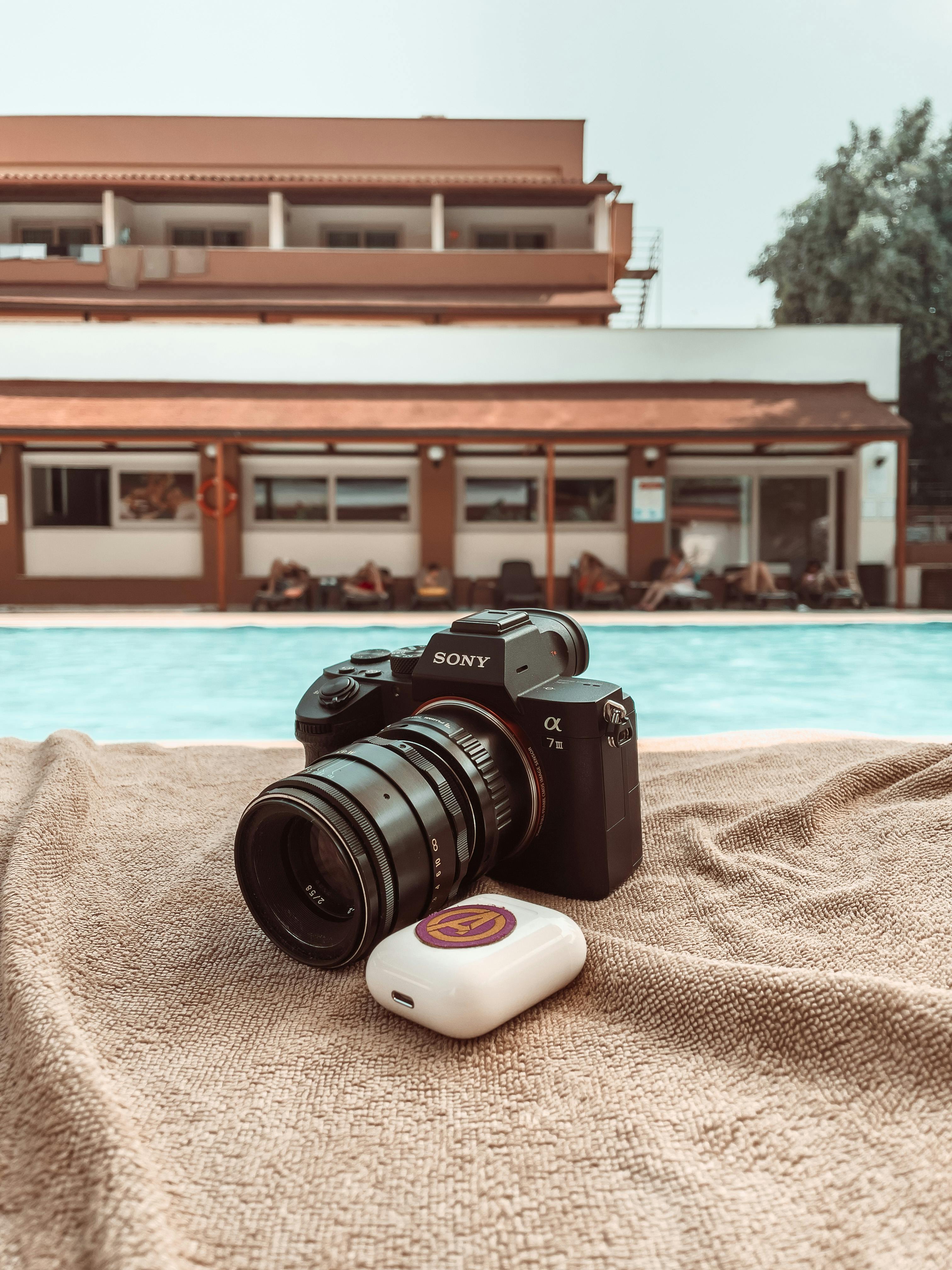 SLR Camera and a Small Box Lying at the Poolside · Free Stock Photo