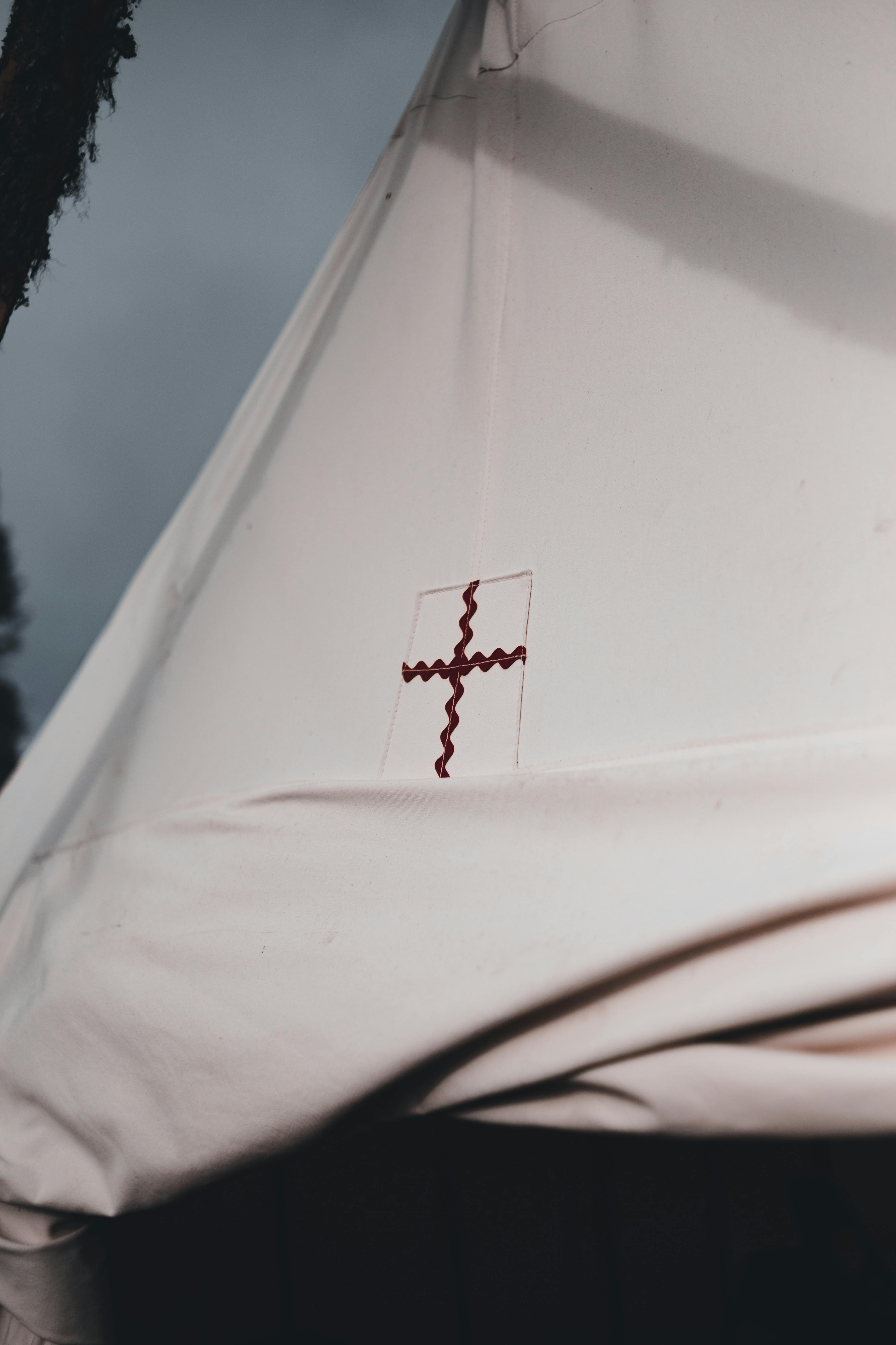 Cross Sign on White Fabric · Free Stock Photo