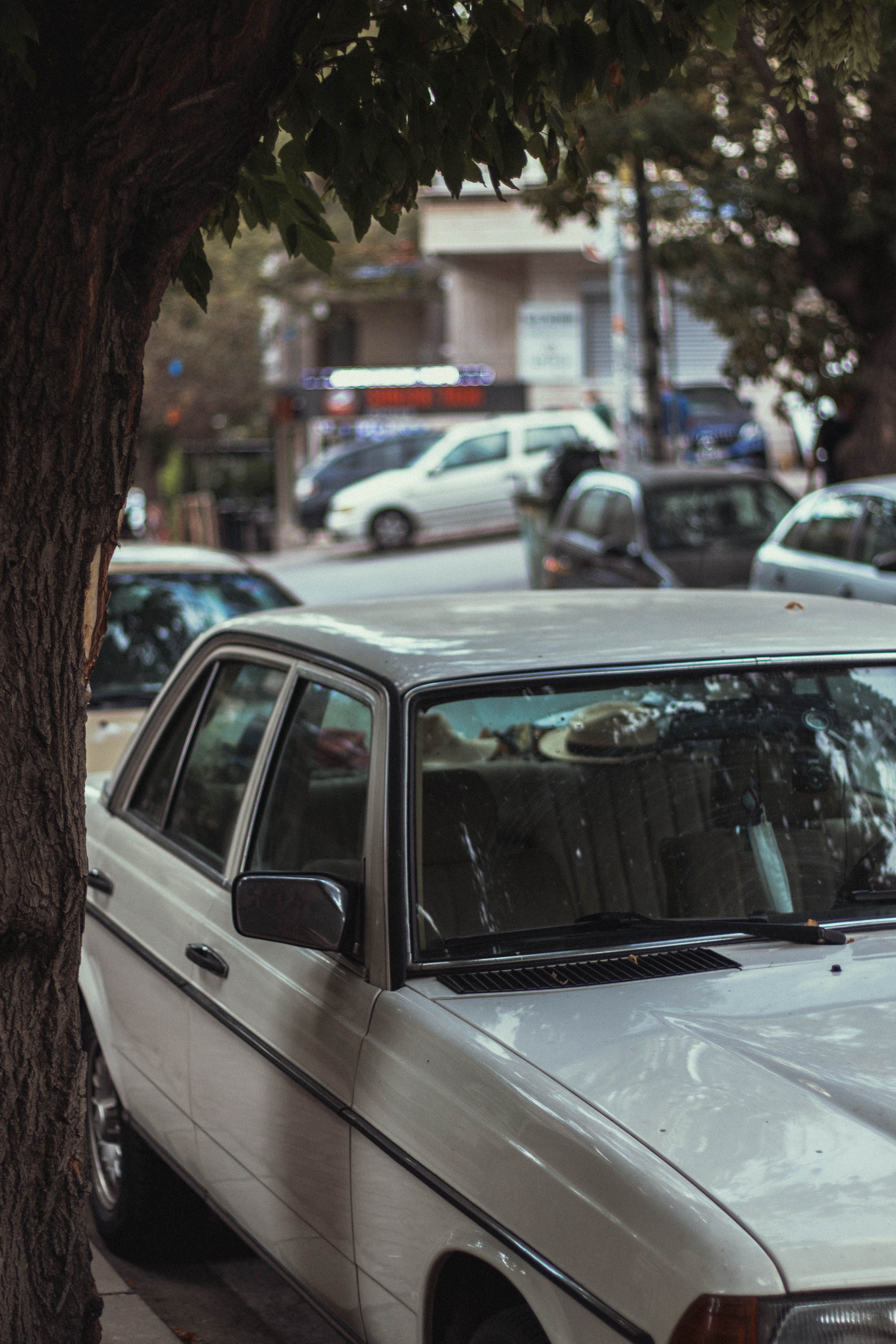 A Vintage Car Parked Beside a Tree · Free Stock Photo
