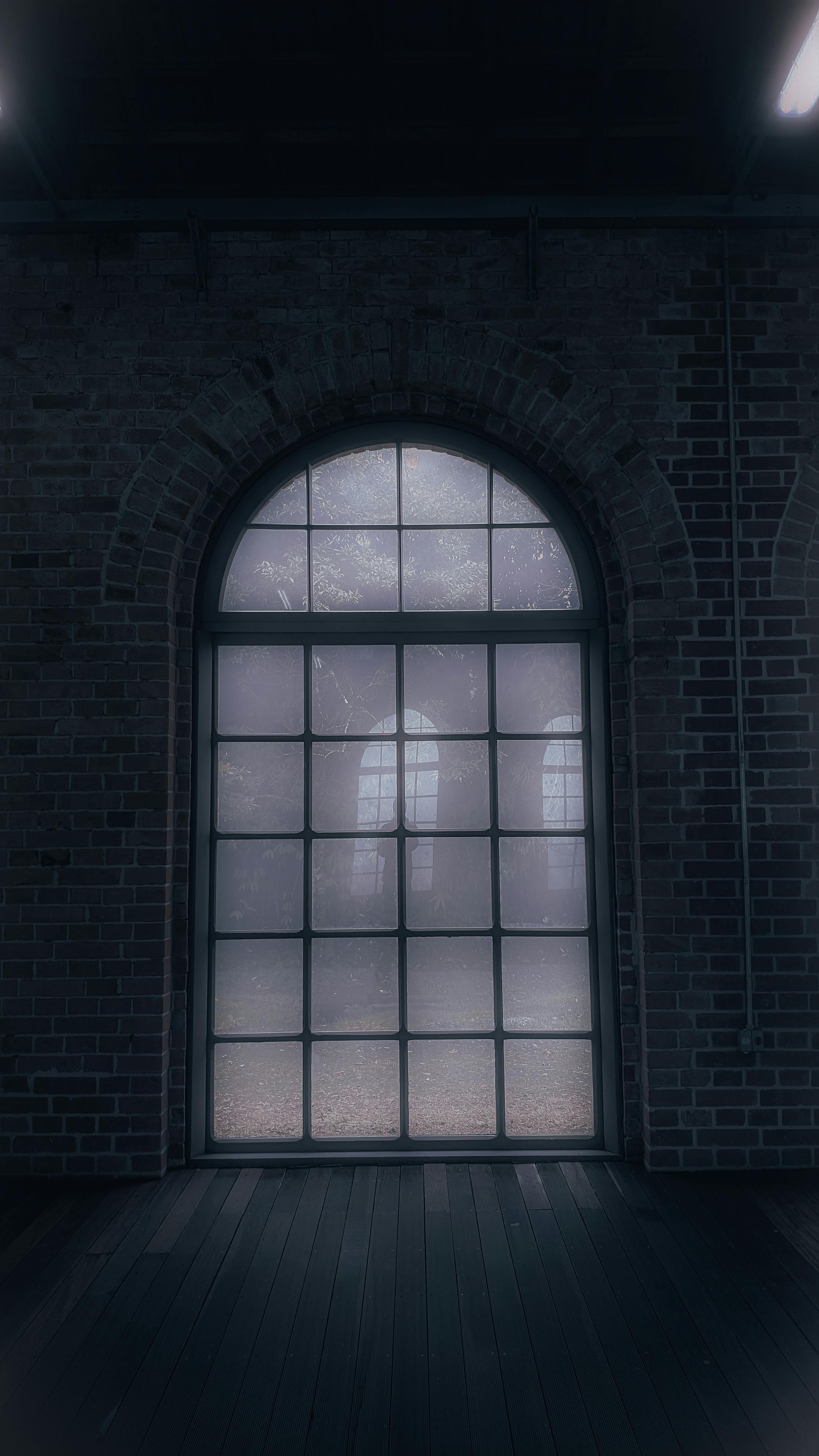 An Arched Glass Window on a Dark Room with Dim Lights · Free Stock Photo