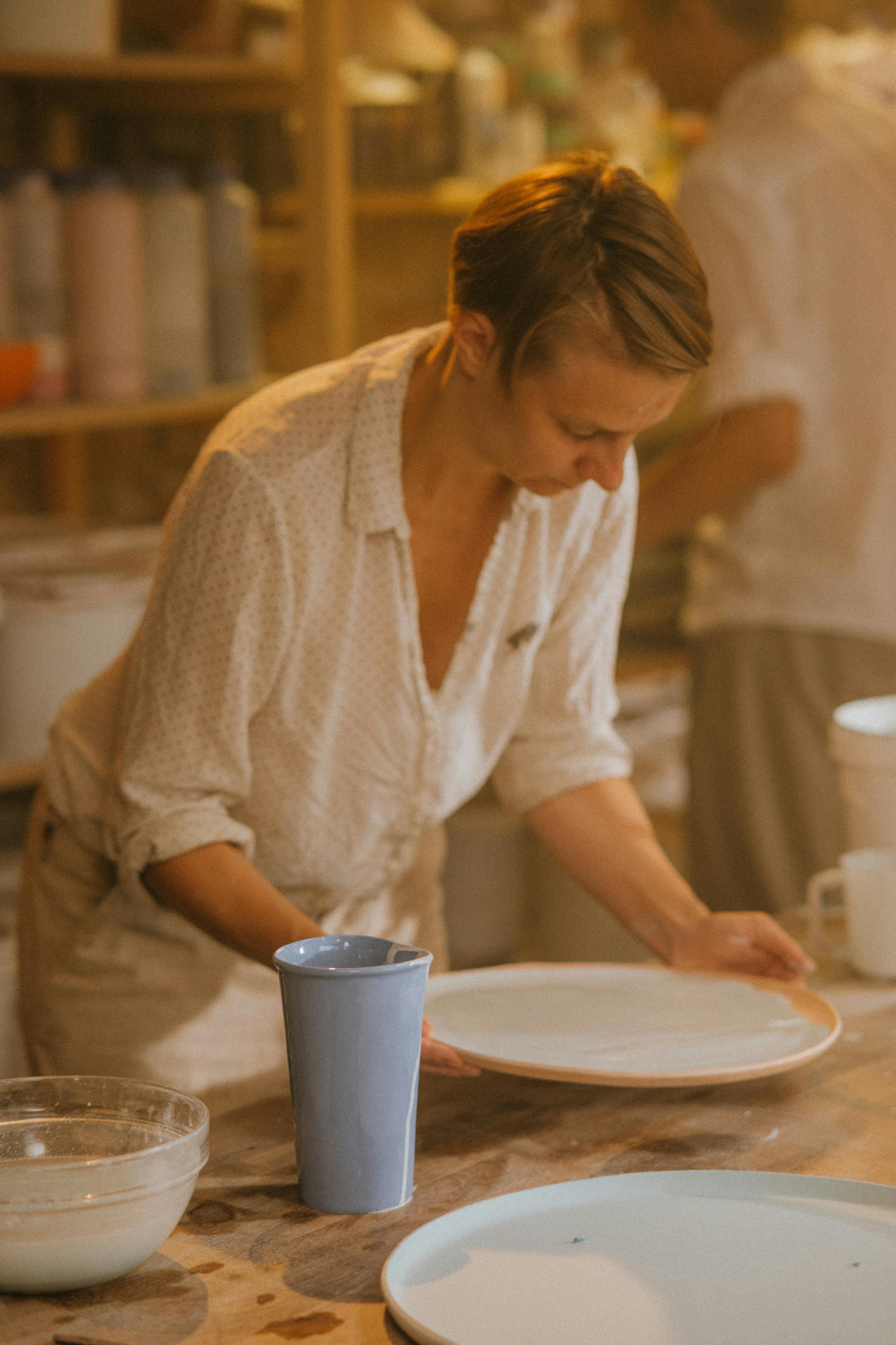 An Artist Glazing a Ceramic Plate · Free Stock Photo