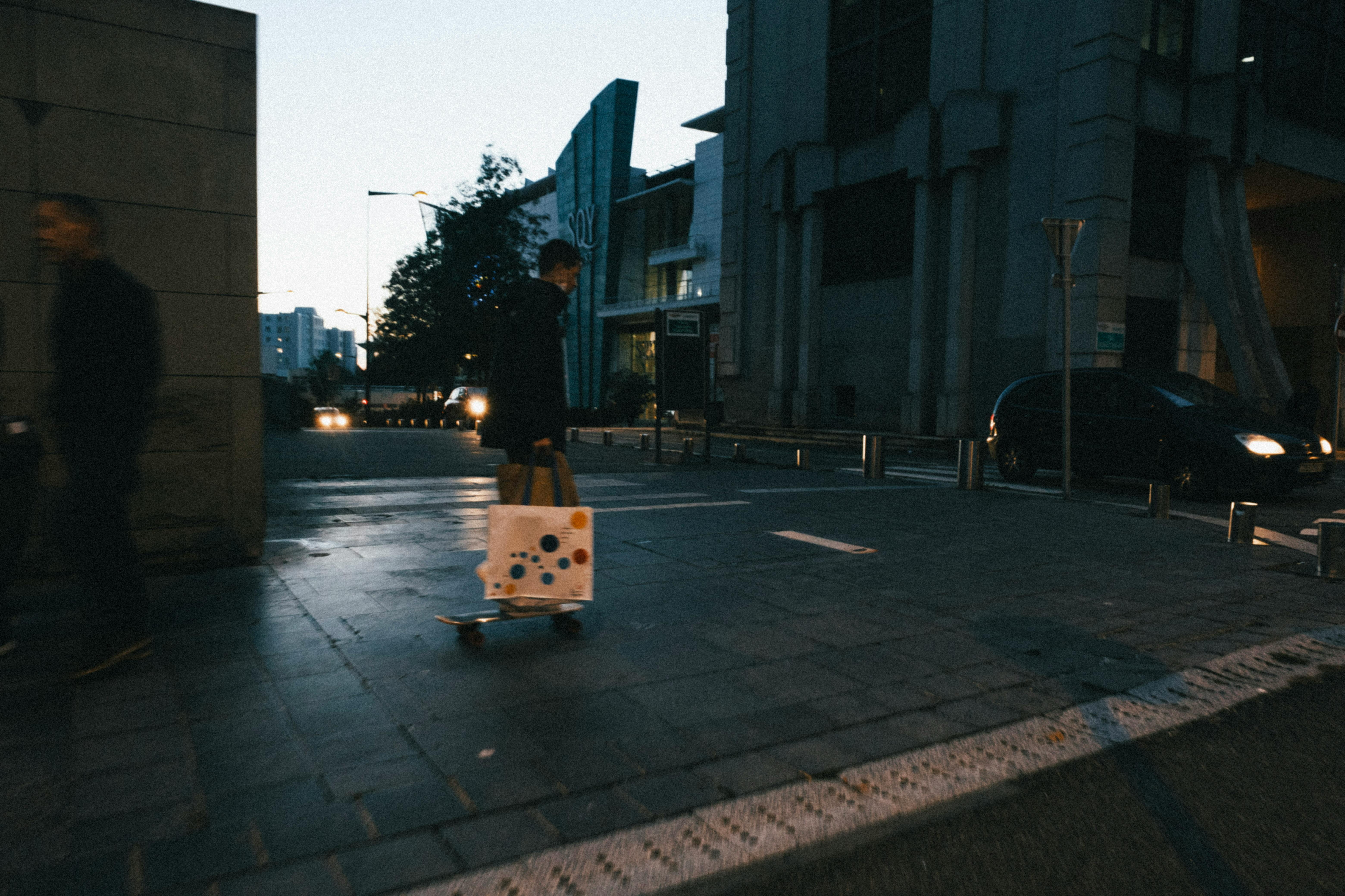 Man Walking in the Sidewalk Carrying a Paper Bag · Free Stock Photo