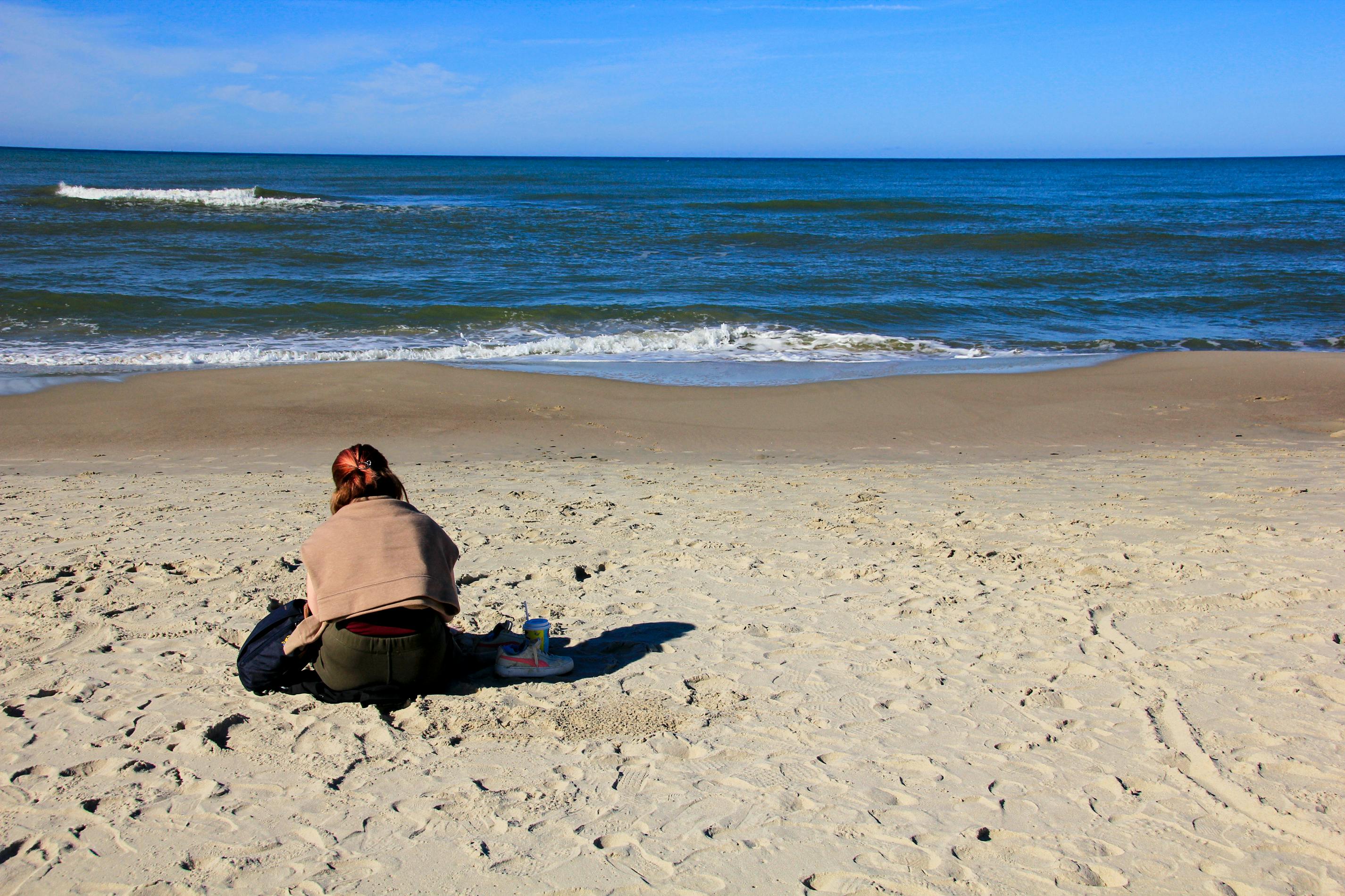 Back View of a Woman in a Bikini Sitting on the Beach · Free Stock Photo
