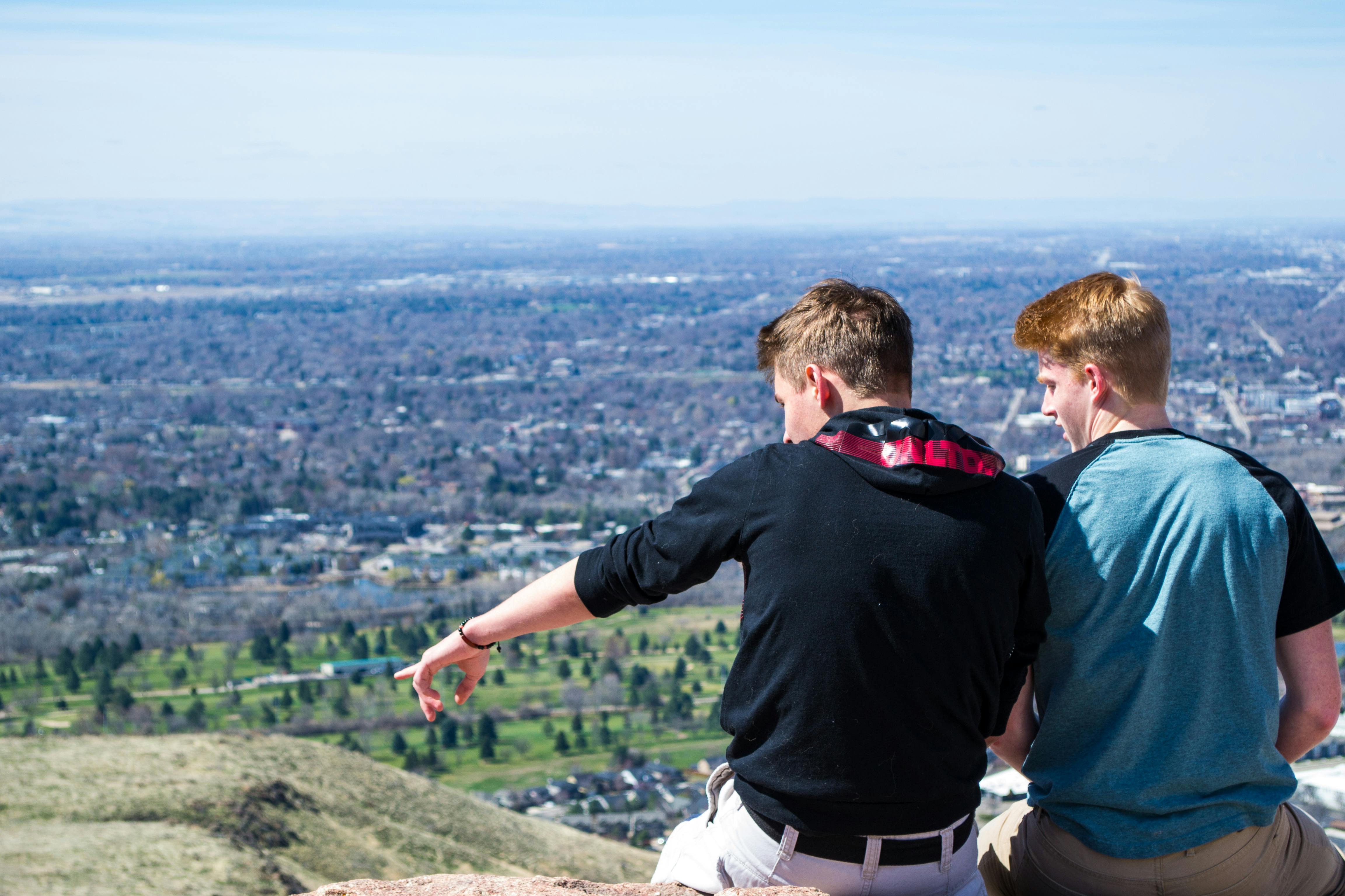 Two Men Sitting on Hill · Free Stock Photo