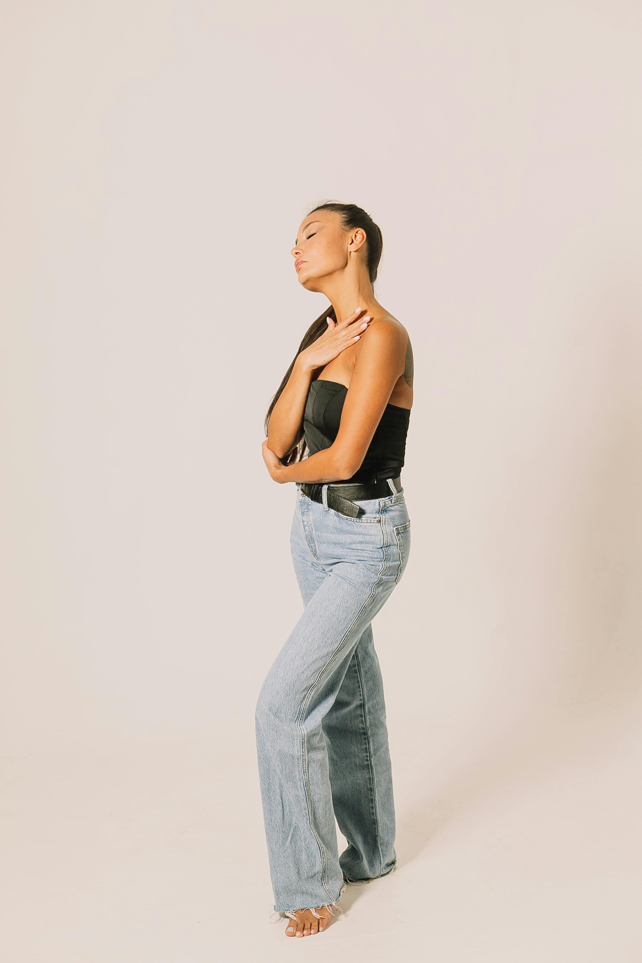 A Woman in White Tube Top and Denim Jeans Posing · Free Stock Photo