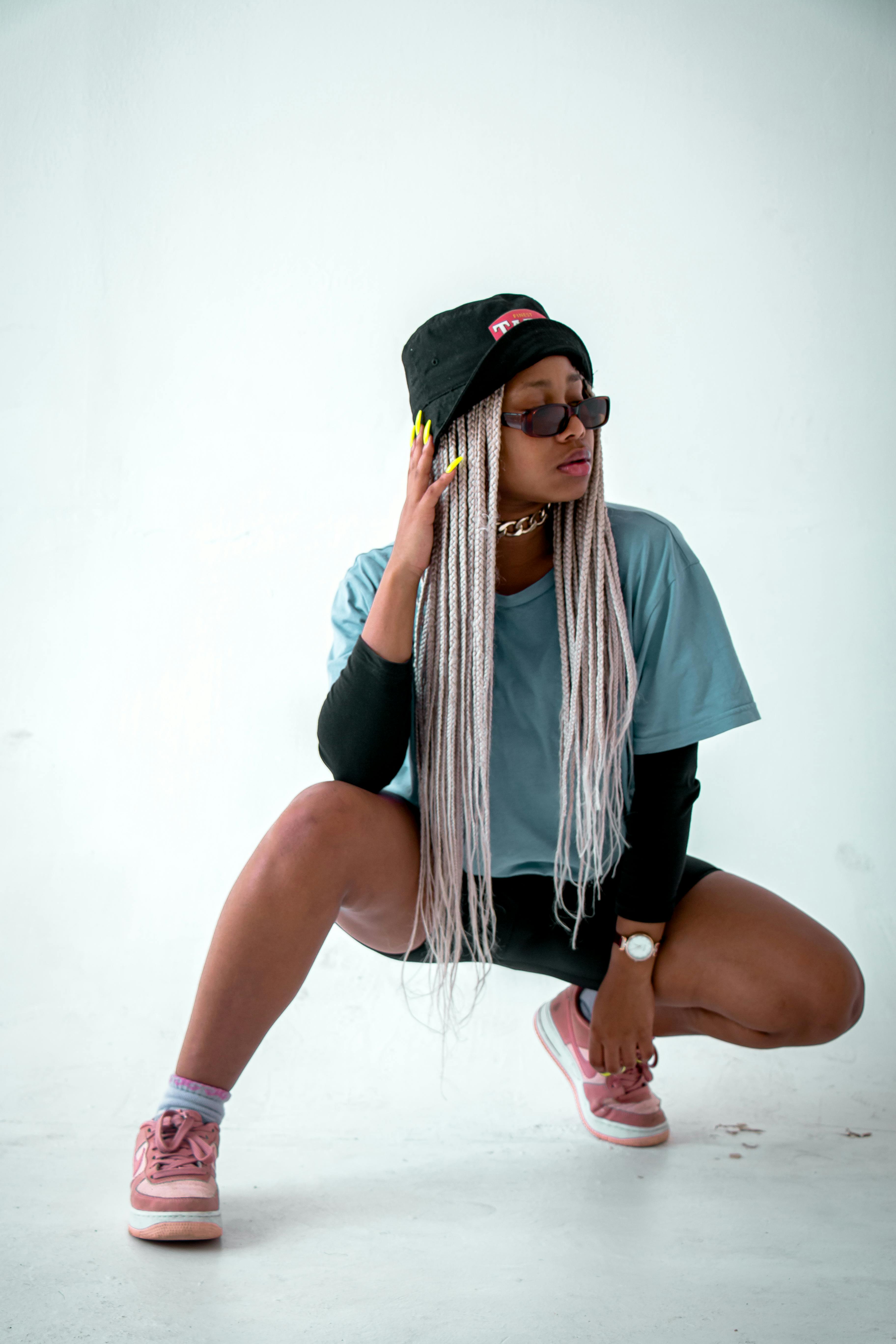 A Woman with Braided Hair Wearing a Bucket Hat · Free Stock Photo