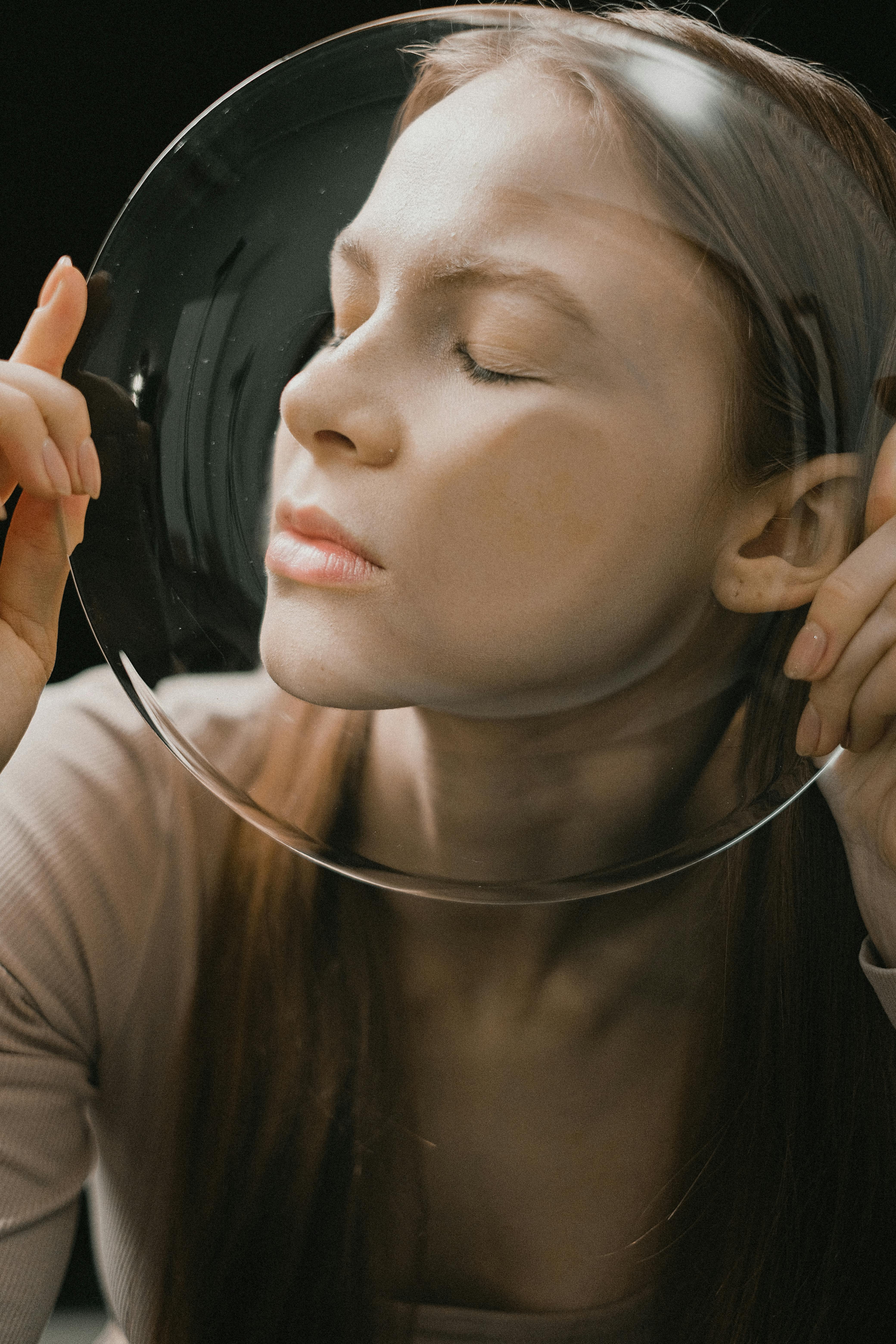 Woman holding see through plate pressed to her face · Free Stock Photo