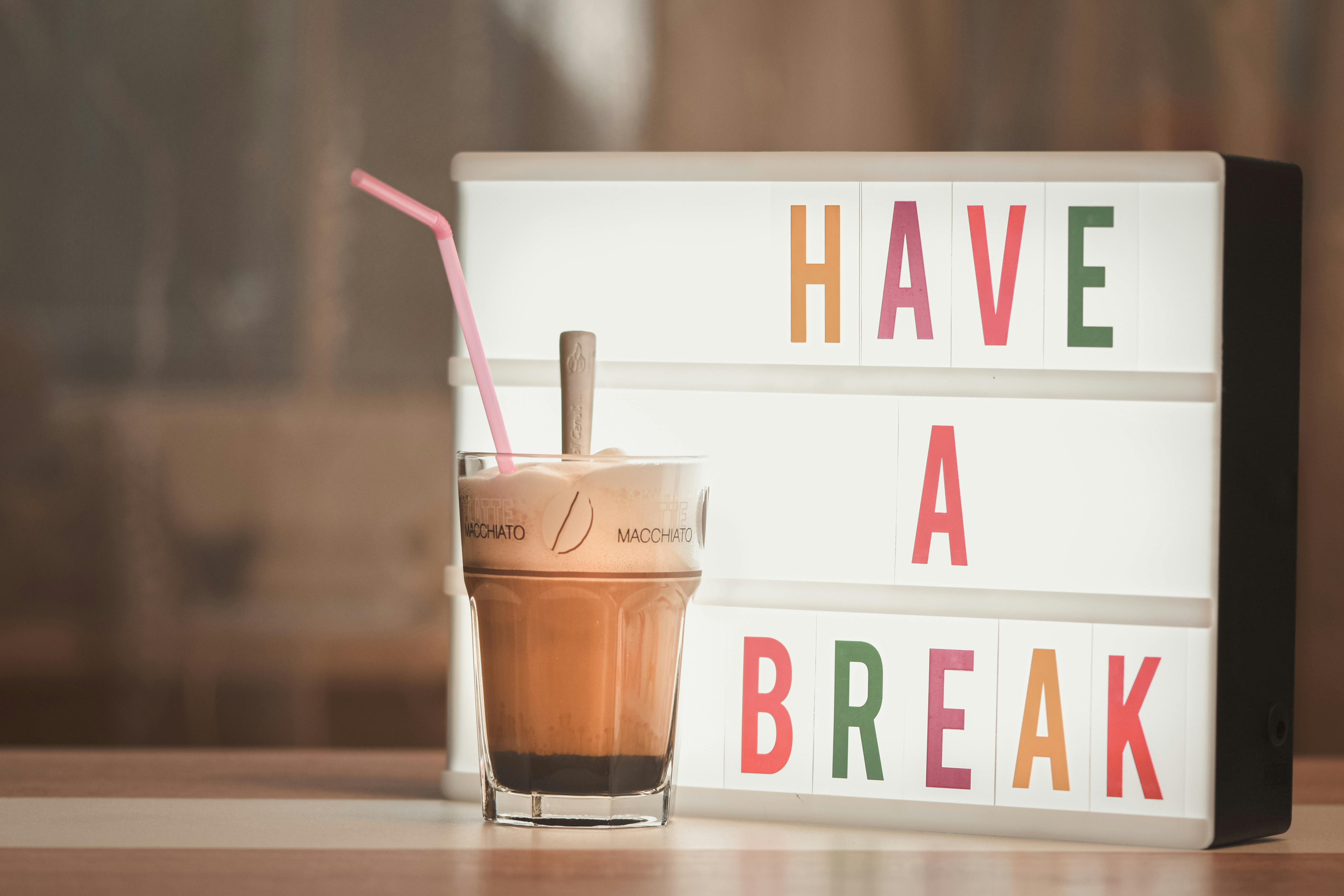 A Have a Break Signage Beside a Cup of Macchiato · Free Stock Photo