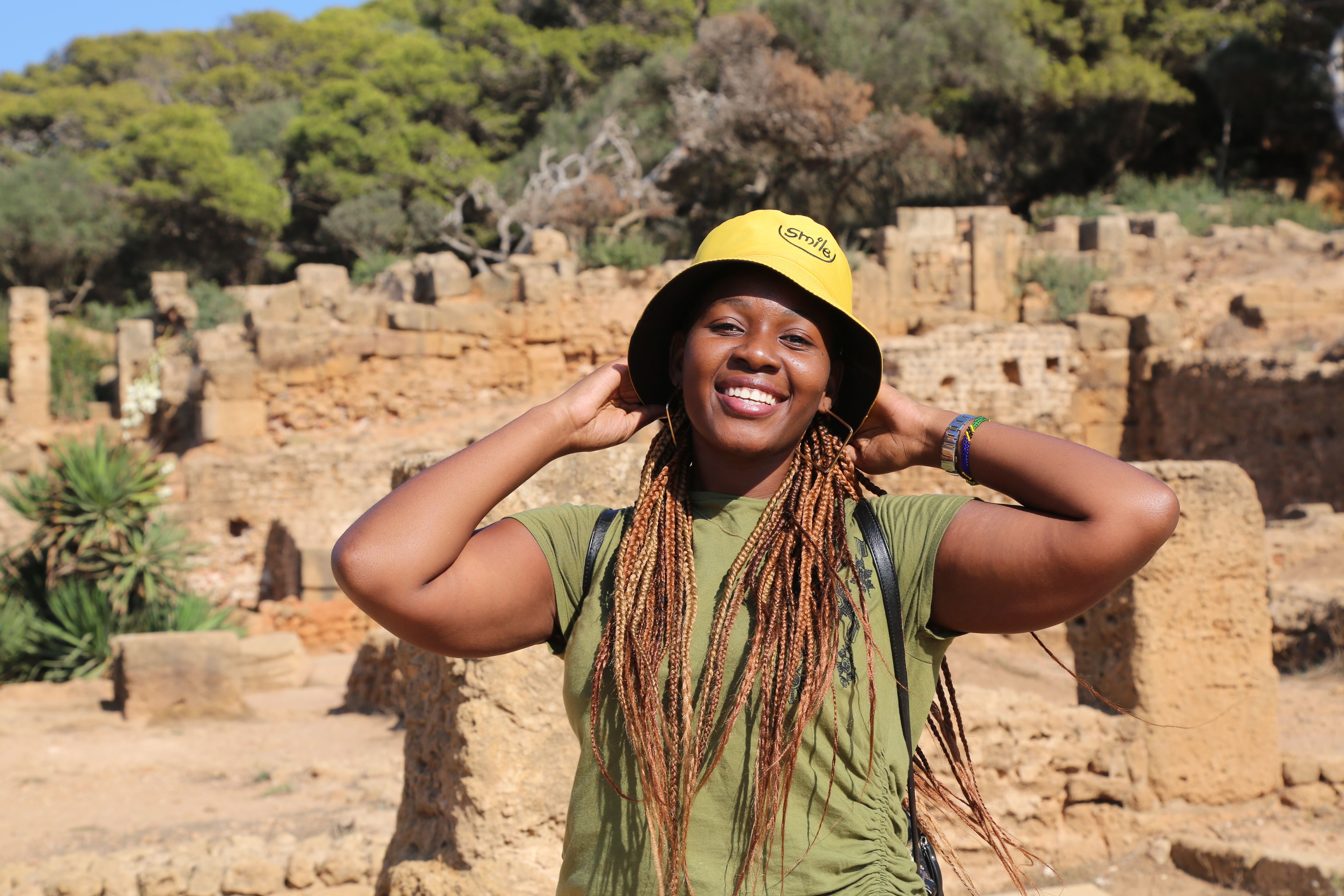 A Woman with Braided Hair Smiling while Wearing a Bucket Hat · Free ...