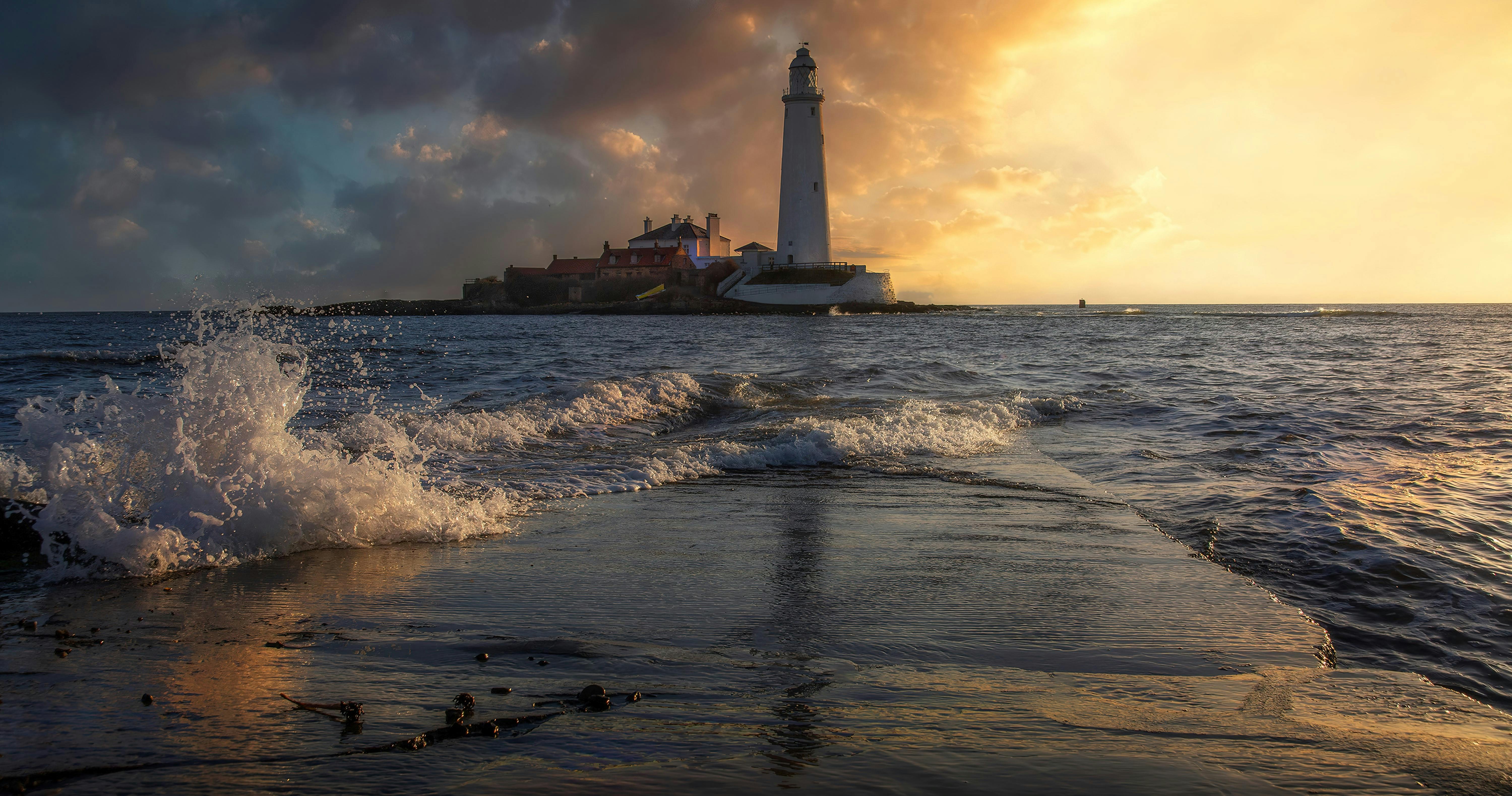 Photo of a Lighthouse on an Island at Sunset · Free Stock Photo