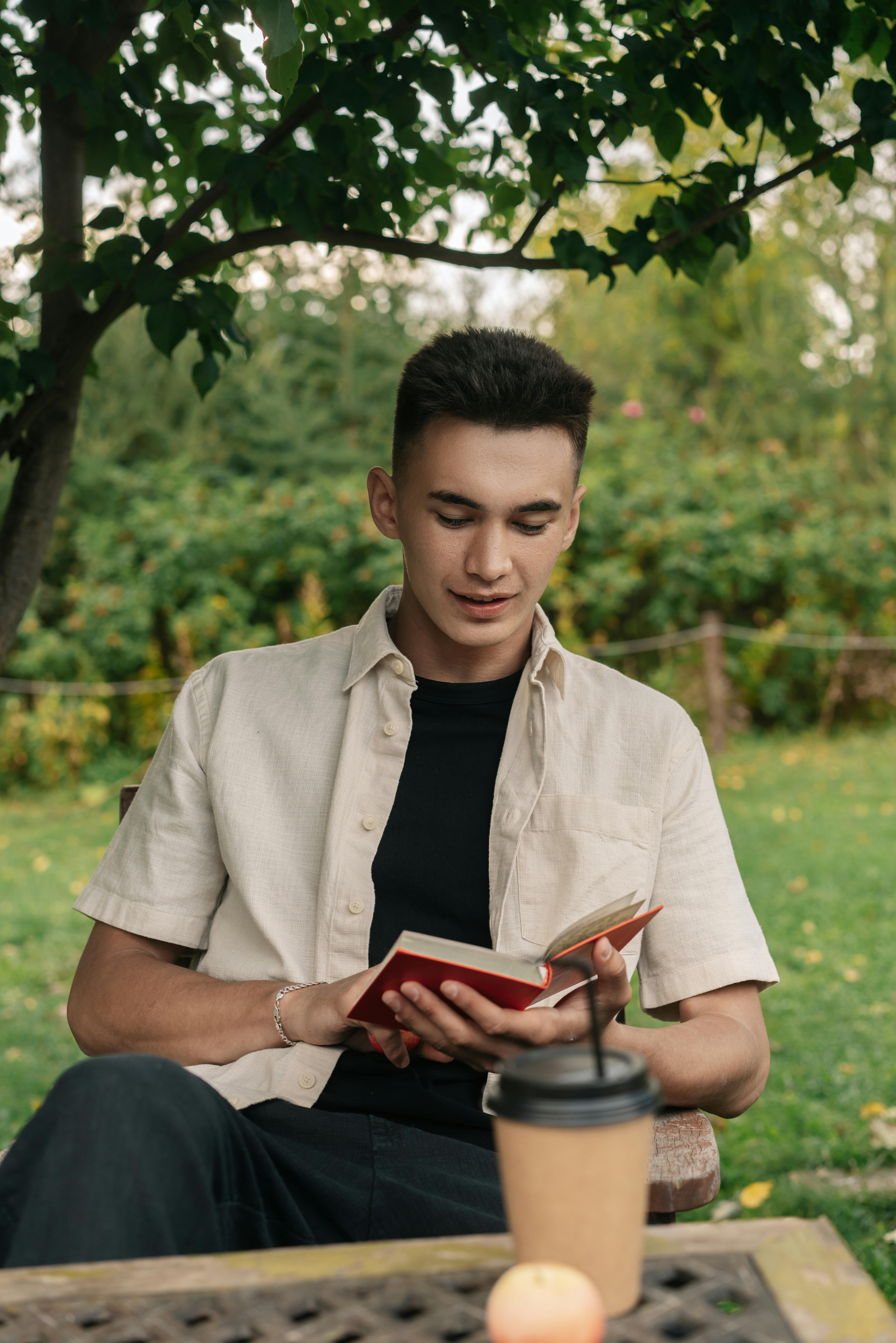 Man Sitting on Chair Reading Book · Free Stock Photo