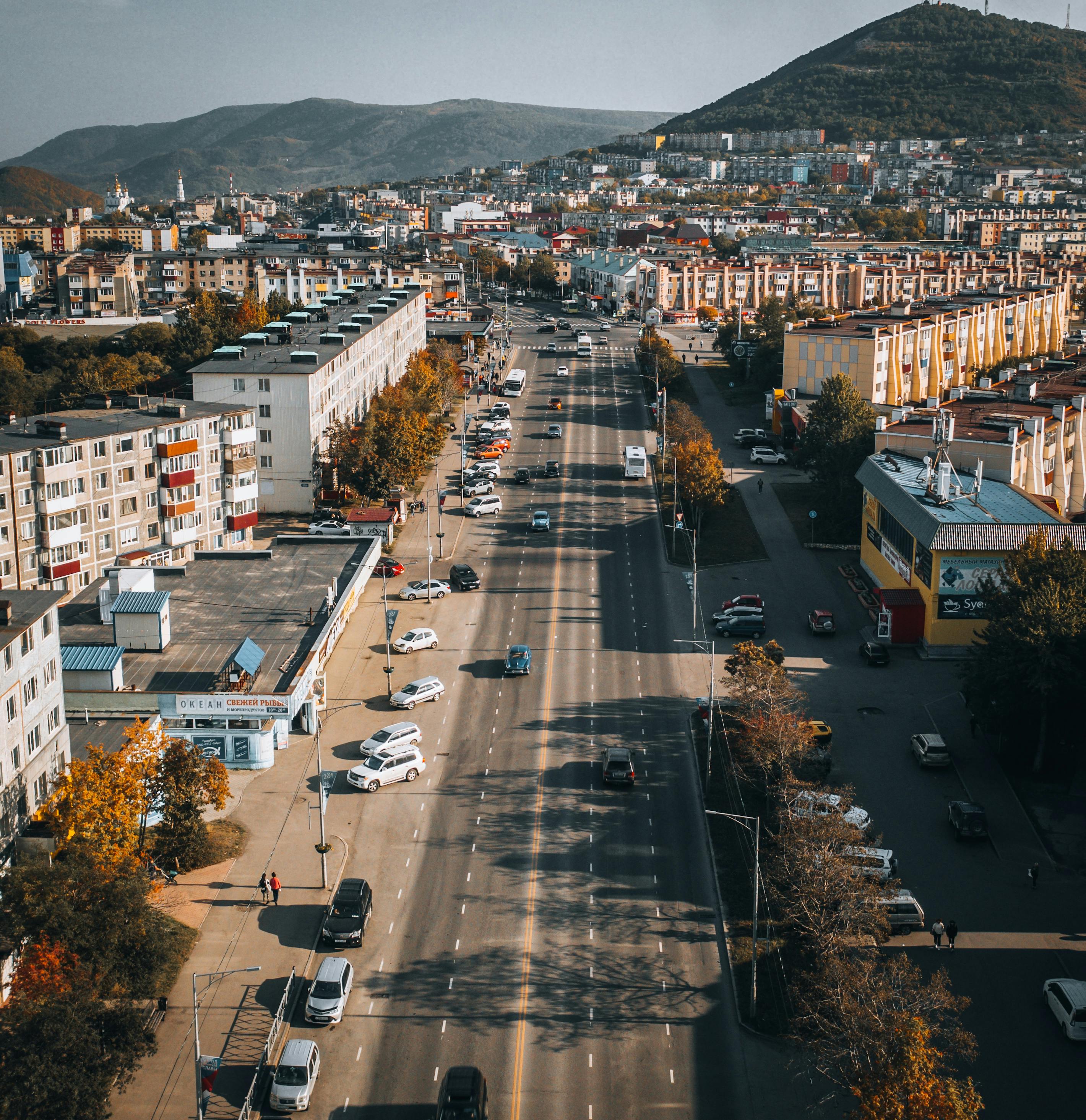An Aerial View of People Walking on the Street Between City Buildings ...