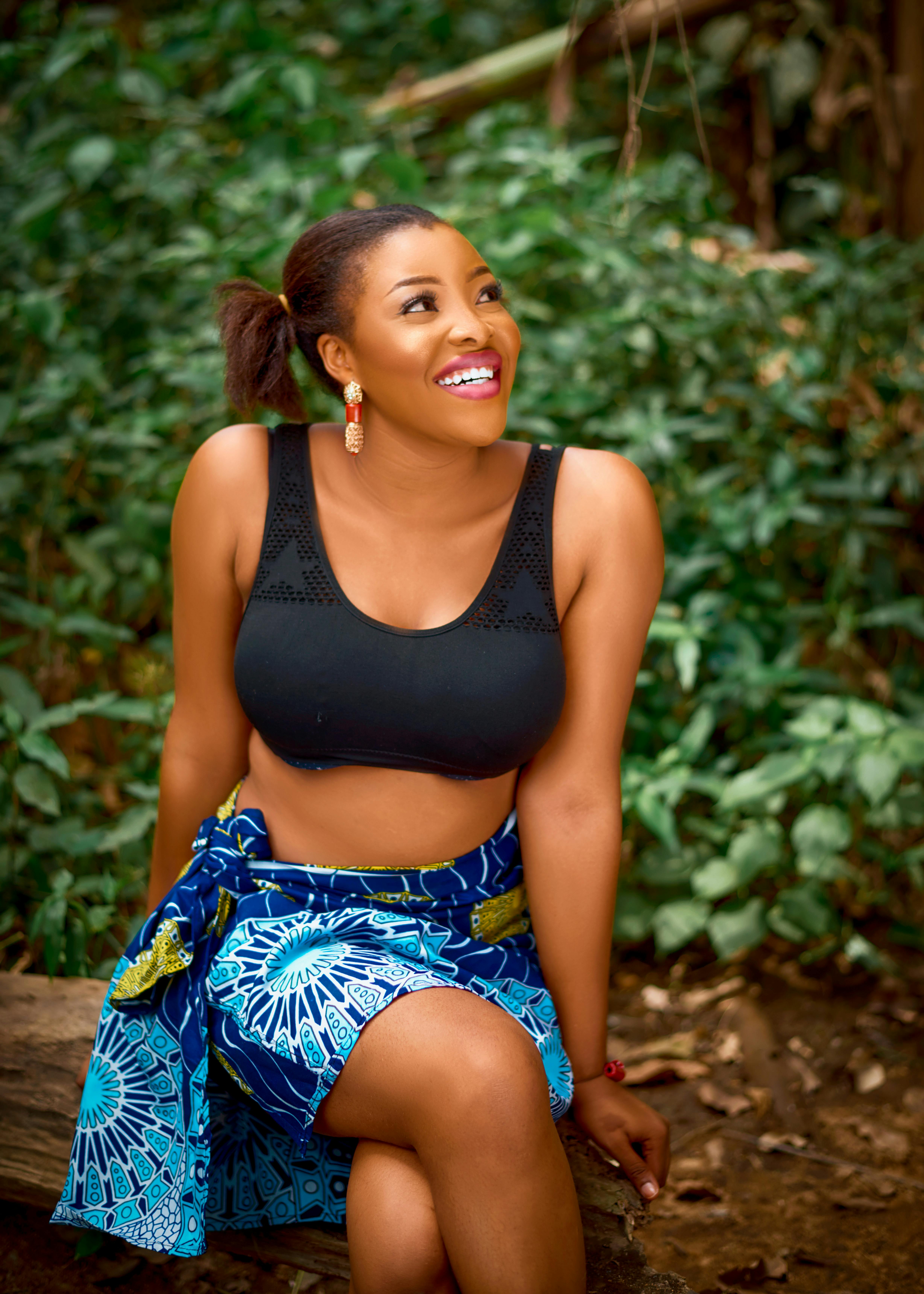 Smiling Woman in Black Sports Bra Looking Up · Free Stock Photo