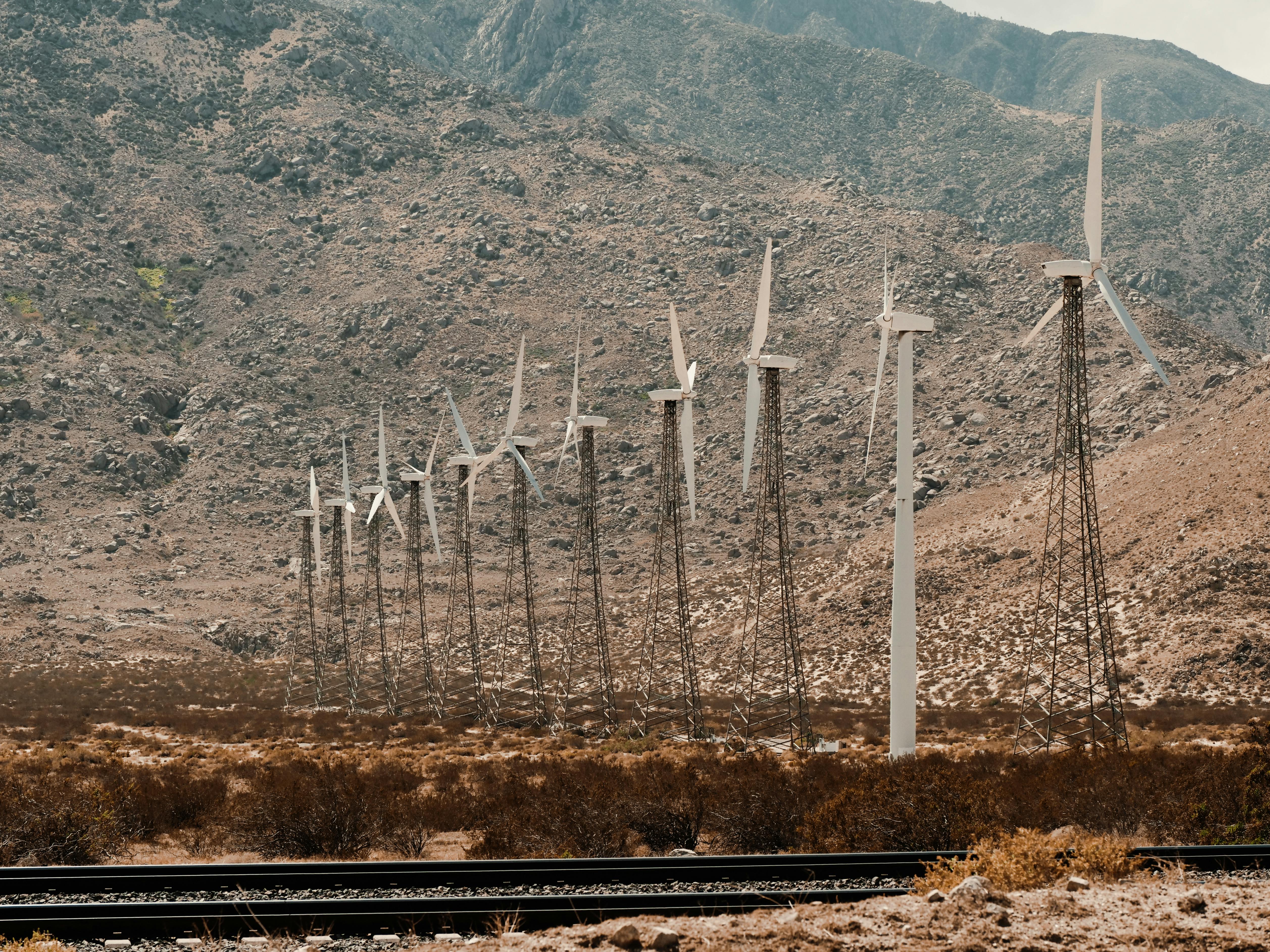 Windmills Beside the Rocky Mountains · Free Stock Photo