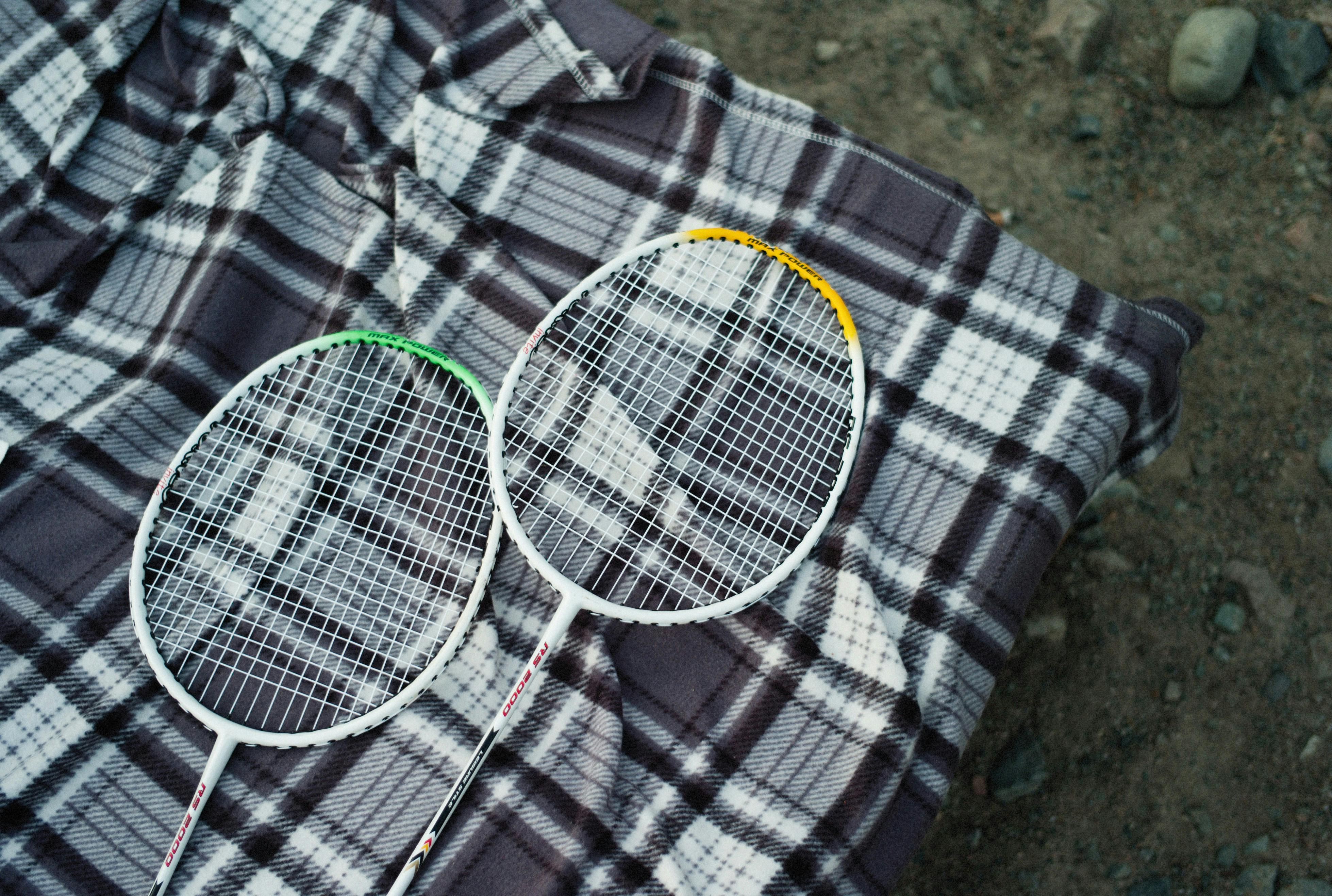 Badminton Rackets on Checkered Textile · Free Stock Photo
