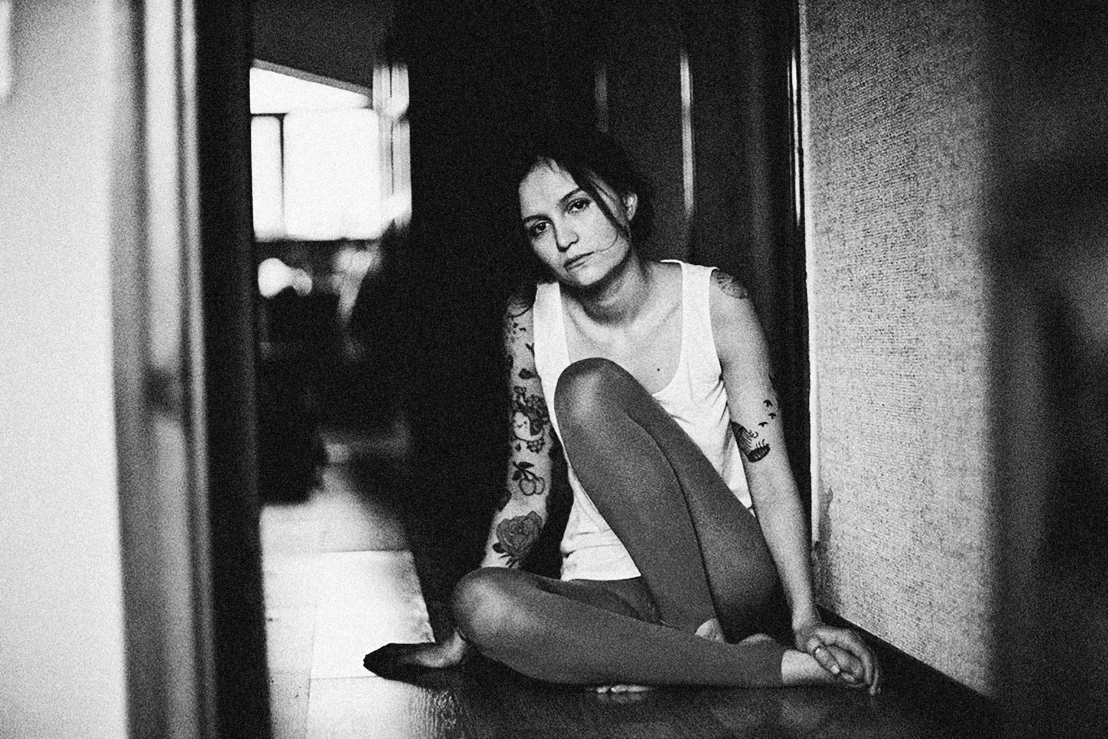 Black and White Photo of a Woman Sitting on the Floor · Free Stock Photo