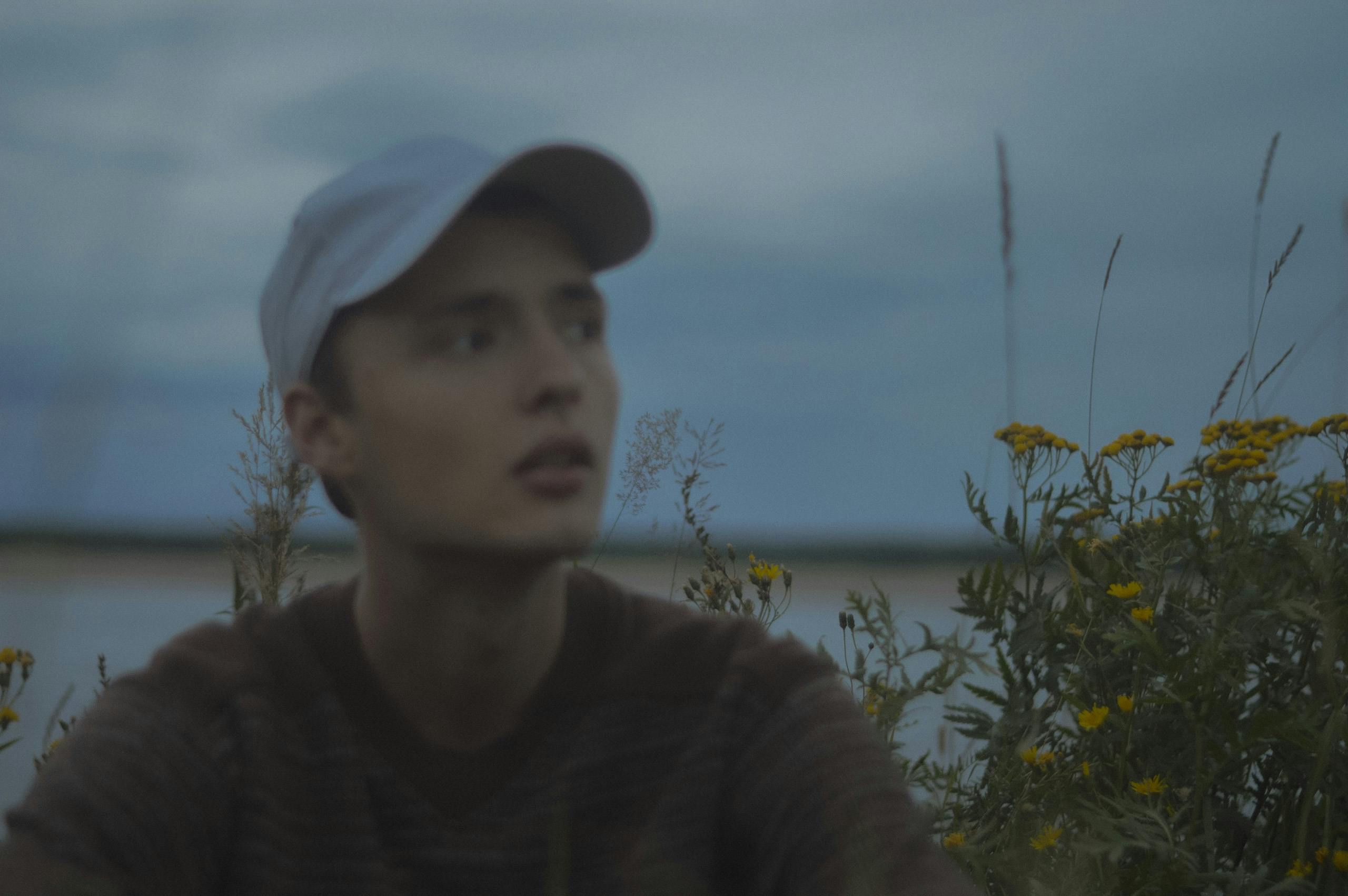A Man Wearing a Cap while Looking Down · Free Stock Photo