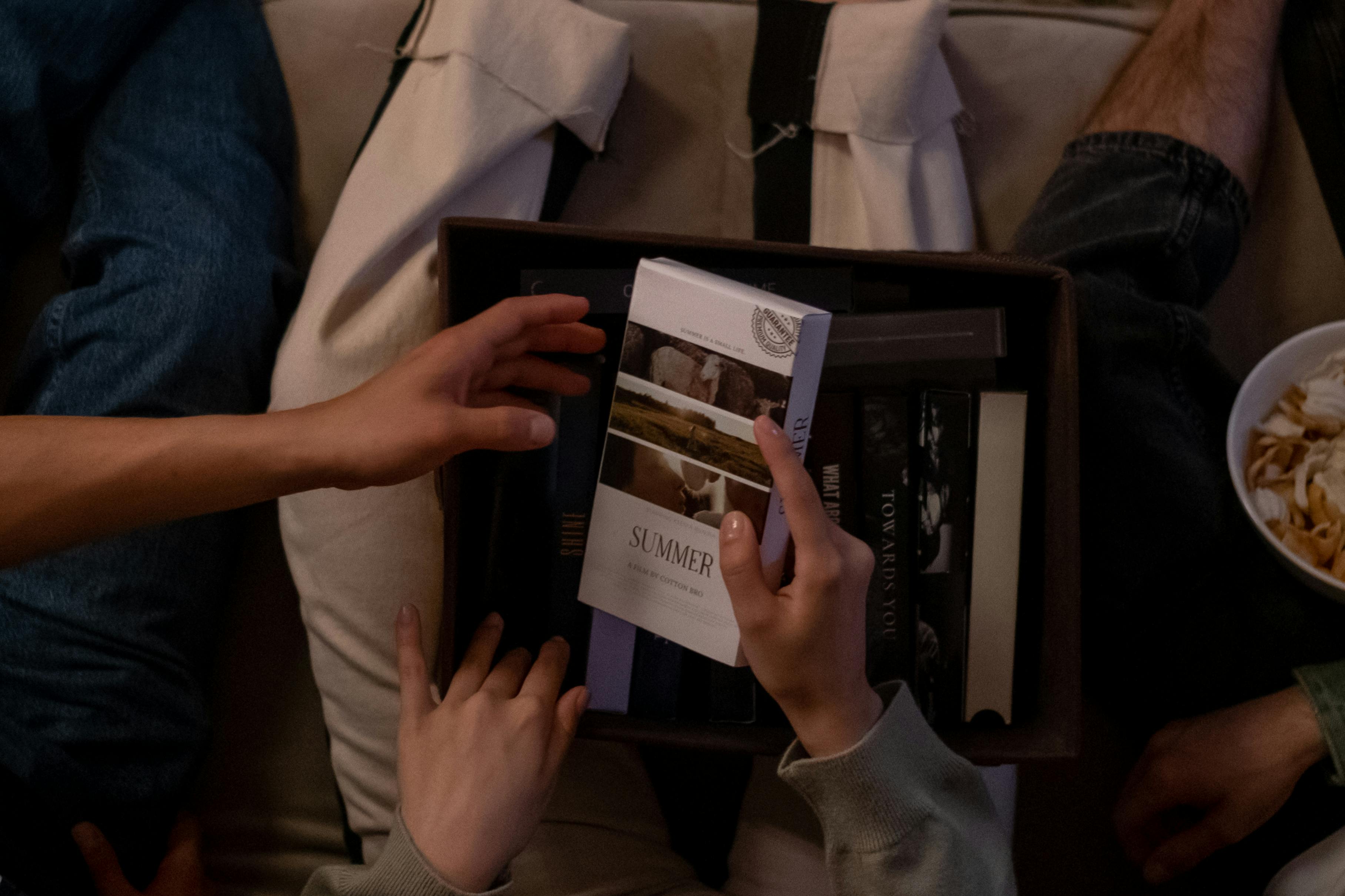 People sitting on the couch and choosing the movie · Free Stock Photo