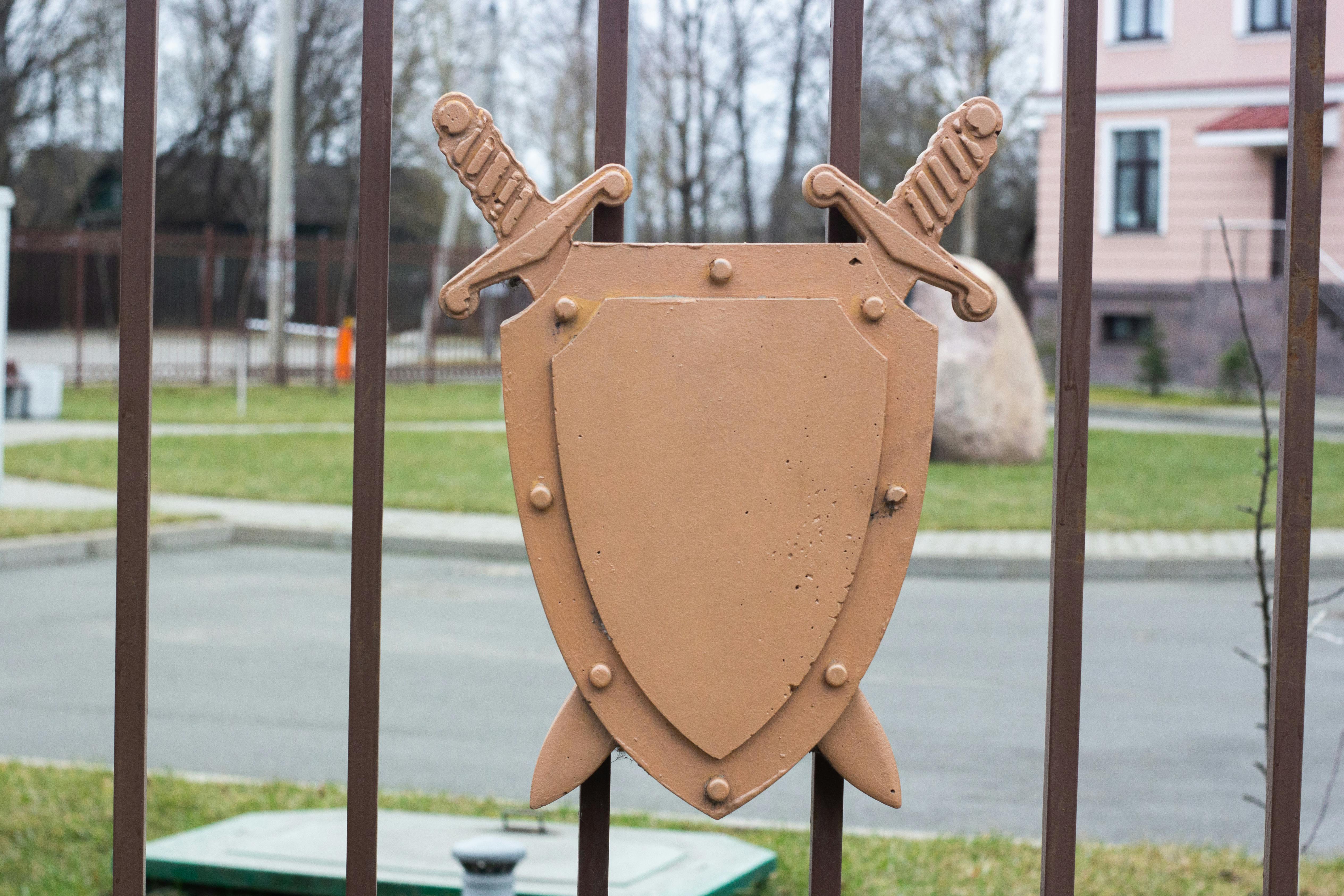 Decoration of a Shield and Swords on a Fence · Free Stock Photo