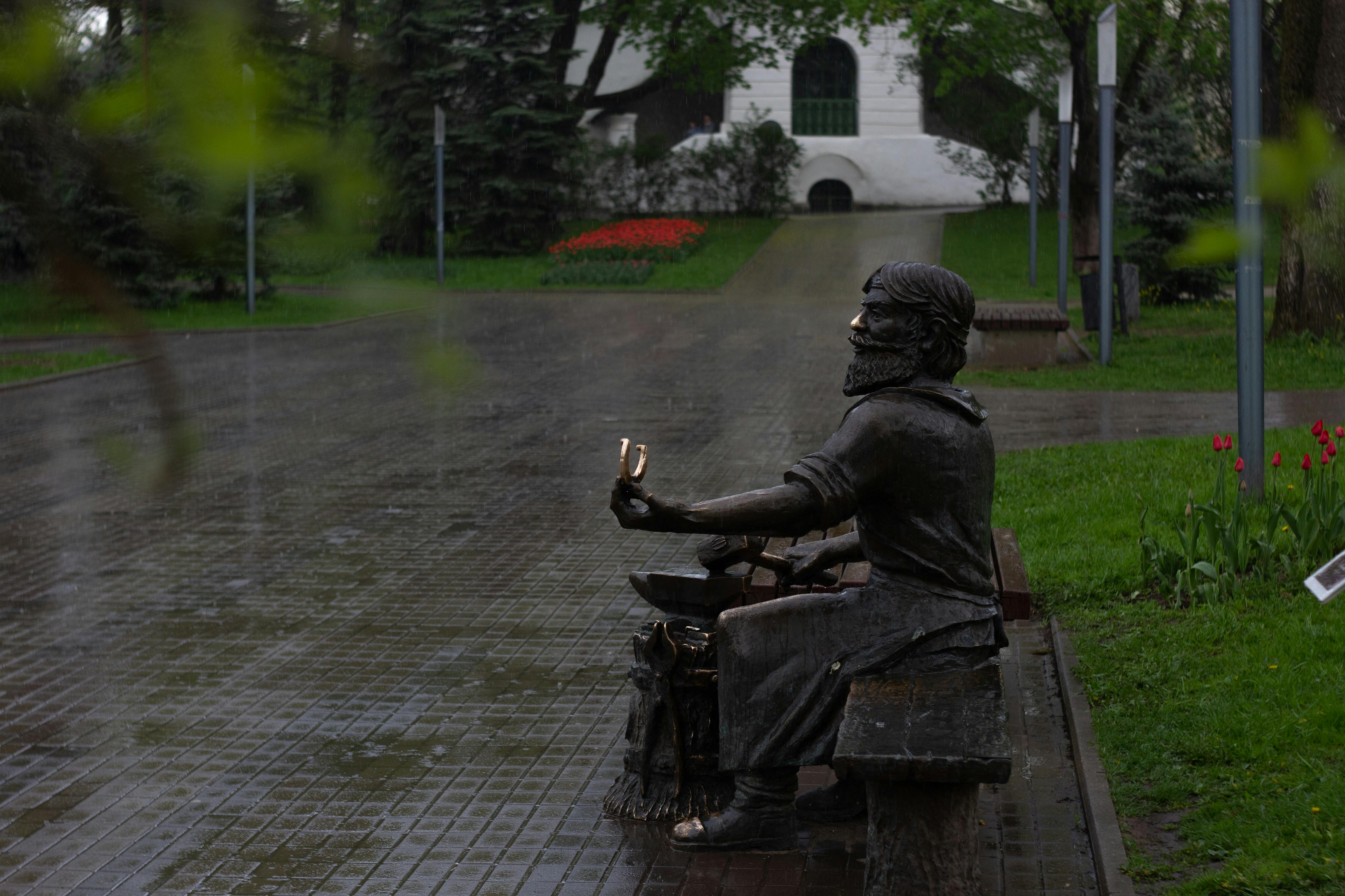 Statue of a Man Sitting on Wooden Bench in the Park · Free Stock Photo