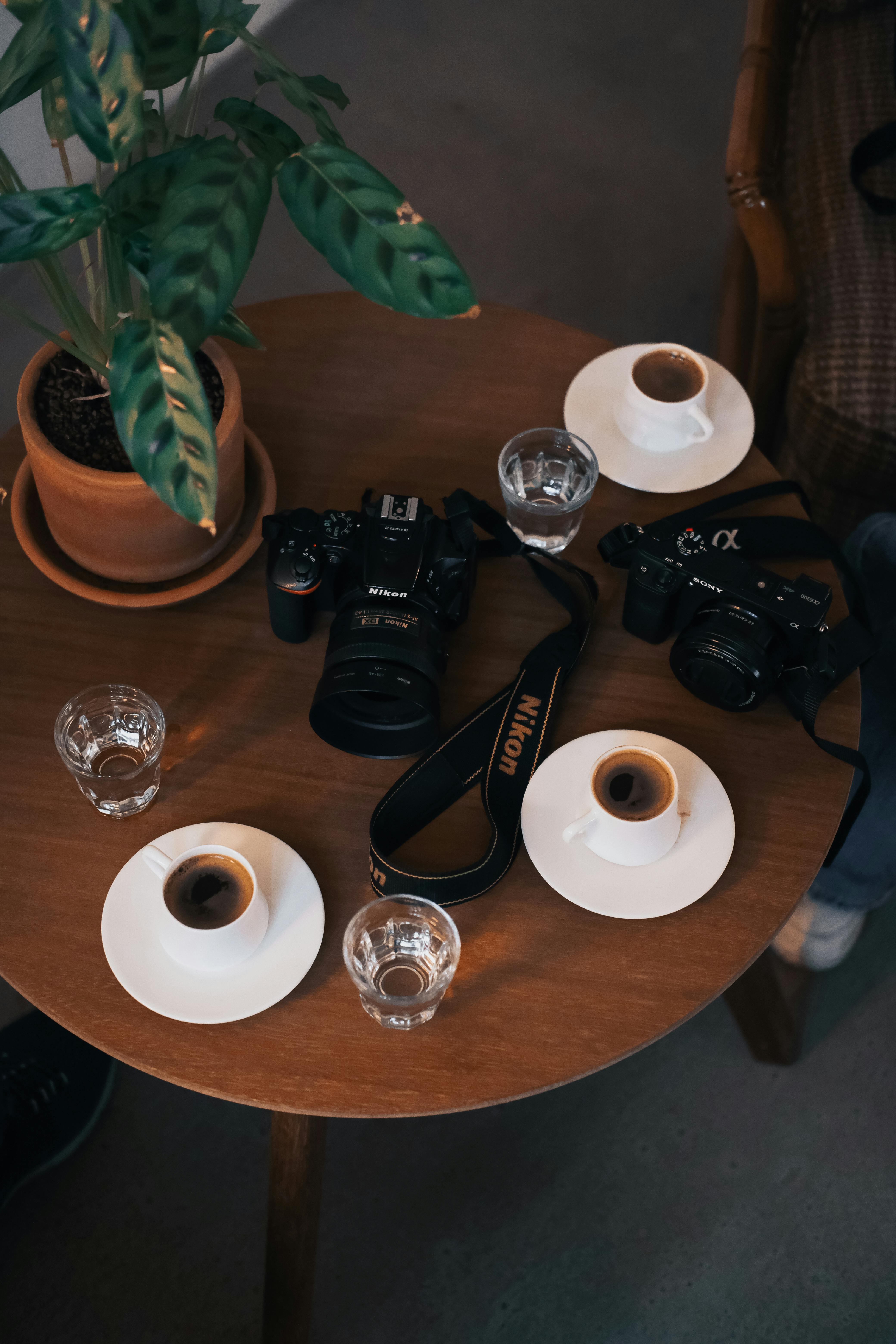 Camera Films and a Cup of Coffee on a Glass Coffee Table · Free Stock Photo