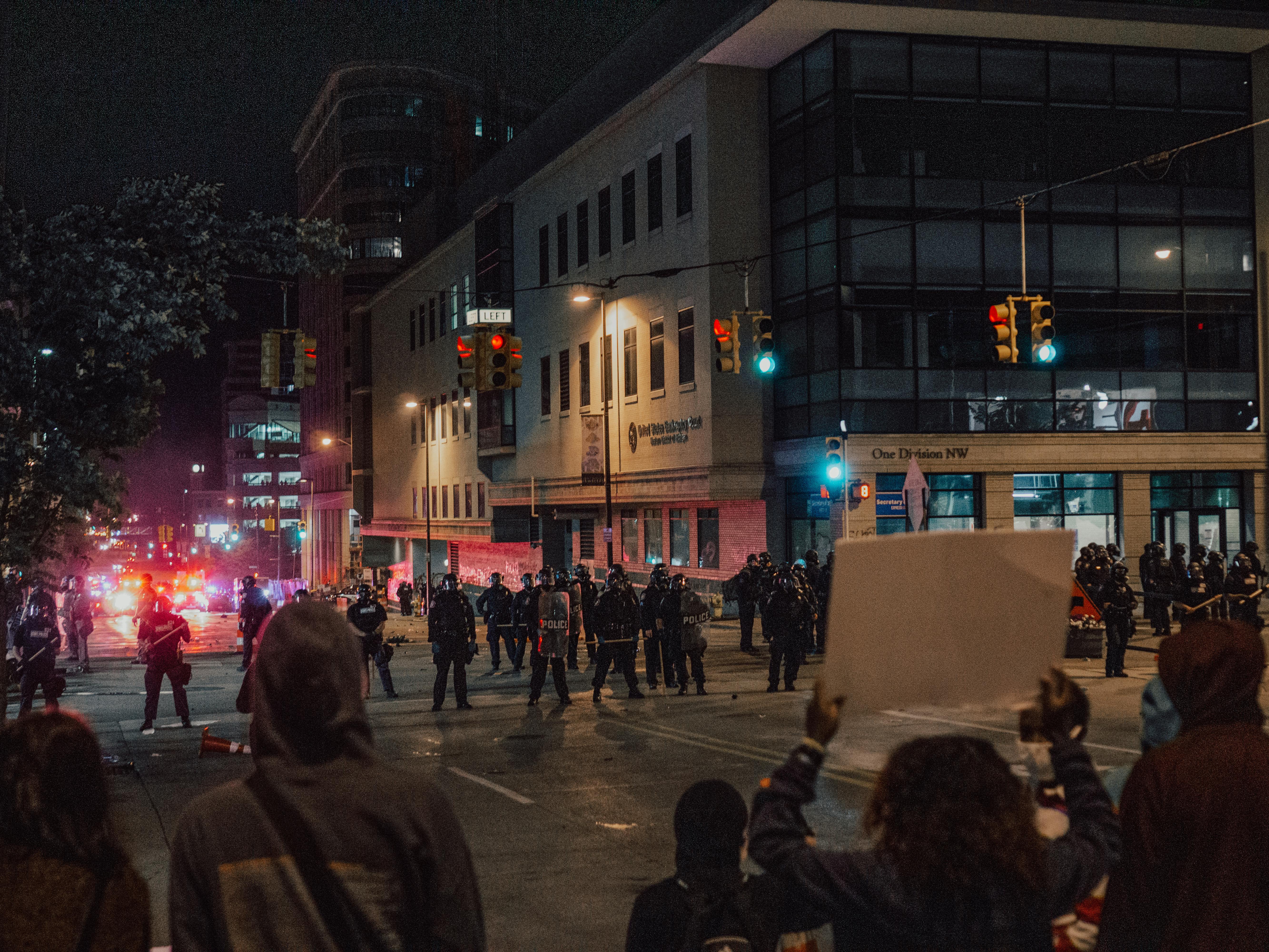 Demonstrators with Protest Signs Facing Police Officers · Free Stock Photo