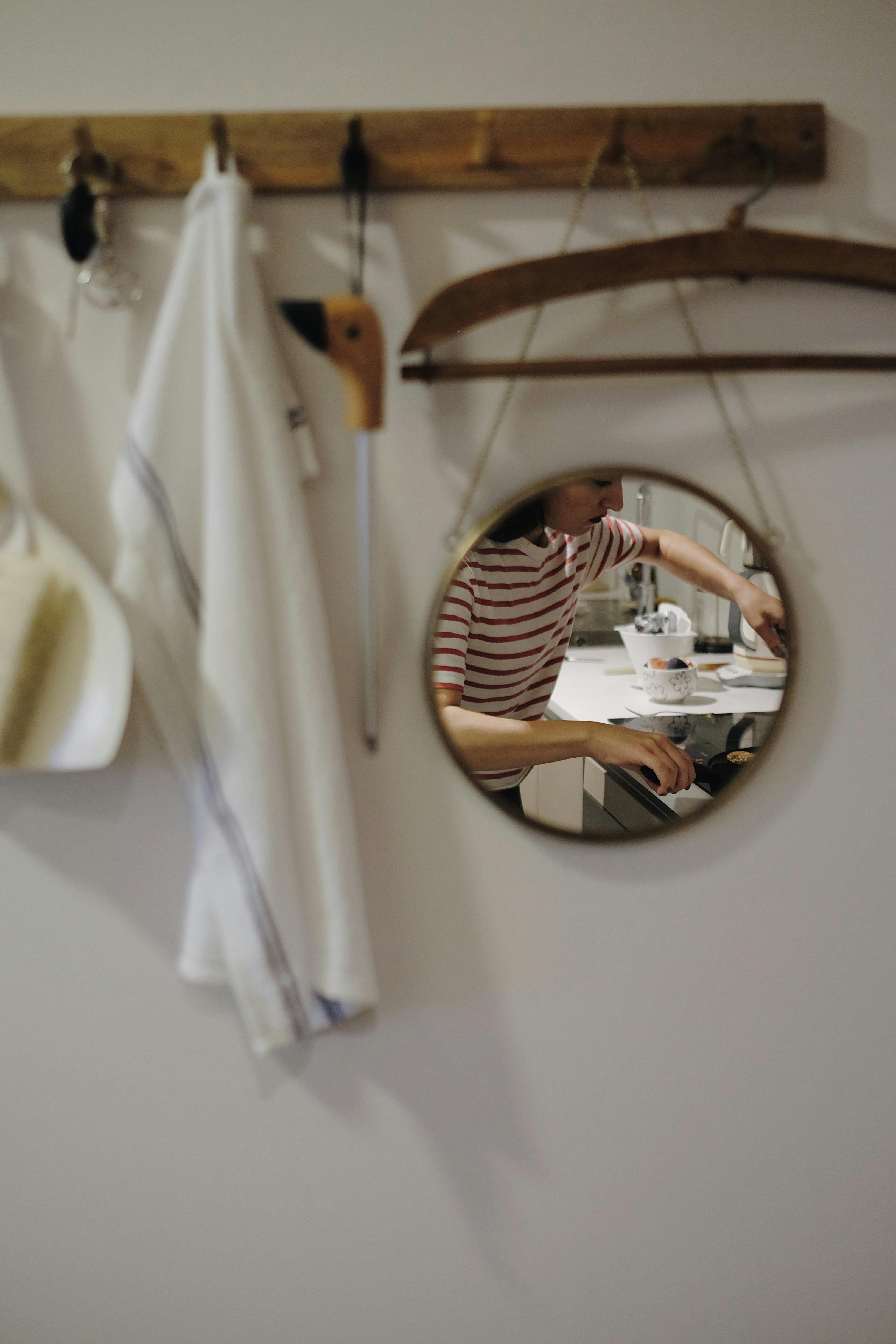 Photograph of the Reflection of a Woman Cooking · Free Stock Photo