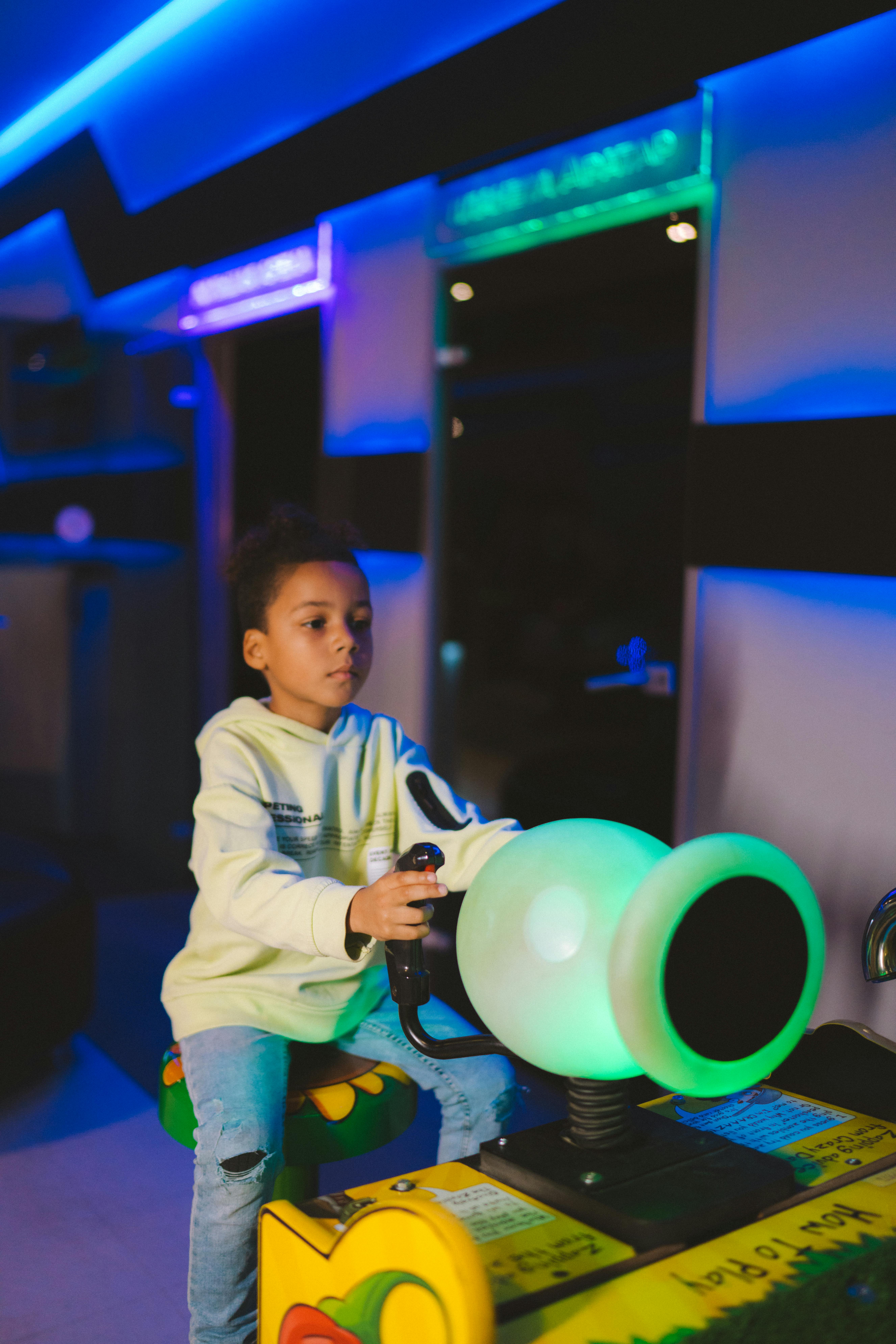 A Boy Playing an Arcade Game · Free Stock Photo