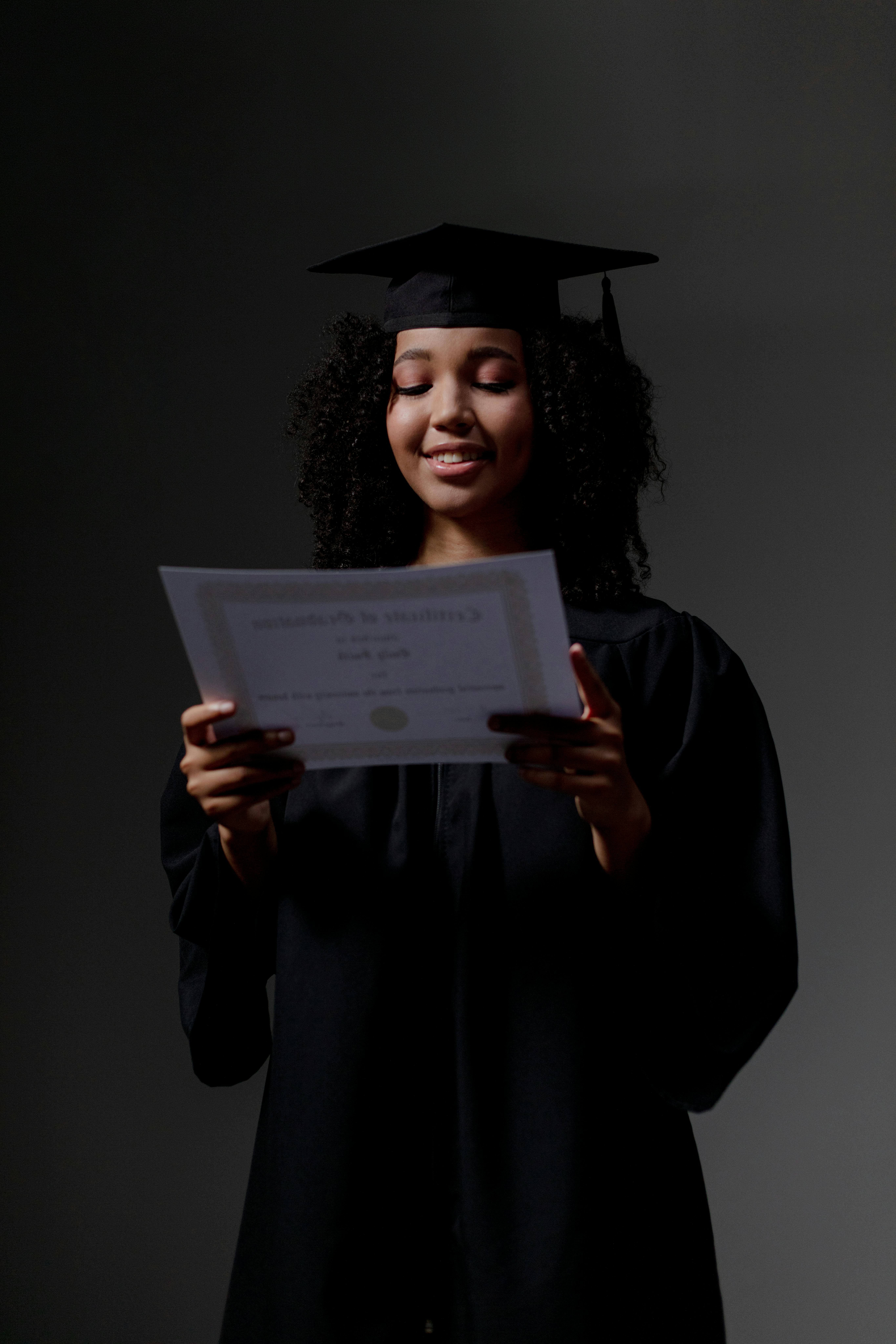 Photo of Woman Wearing Academic Dress and Floral Dress Sitting on ...