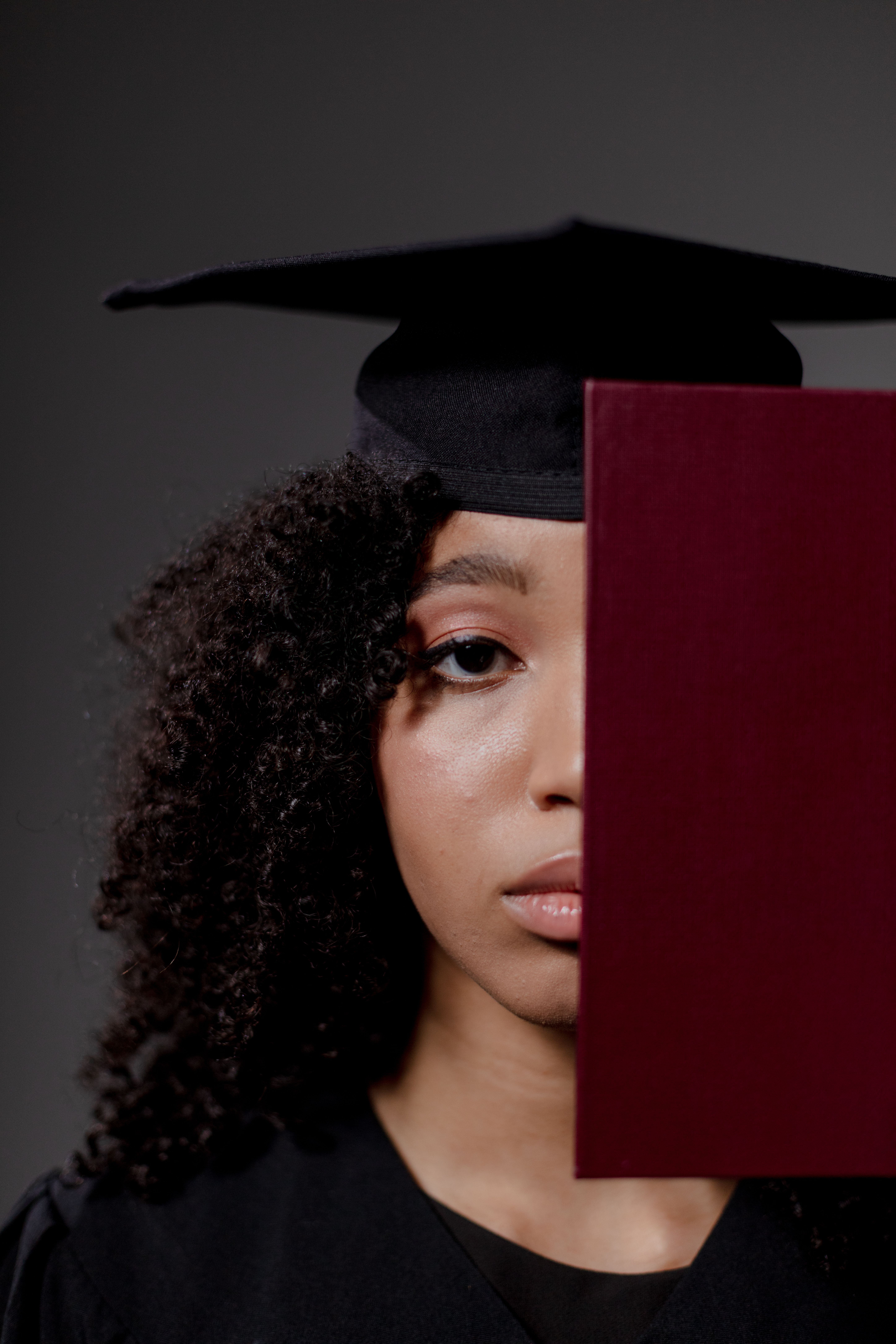 Woman Wearing Black Graduation Coat Sits on Stairs · Free Stock Photo