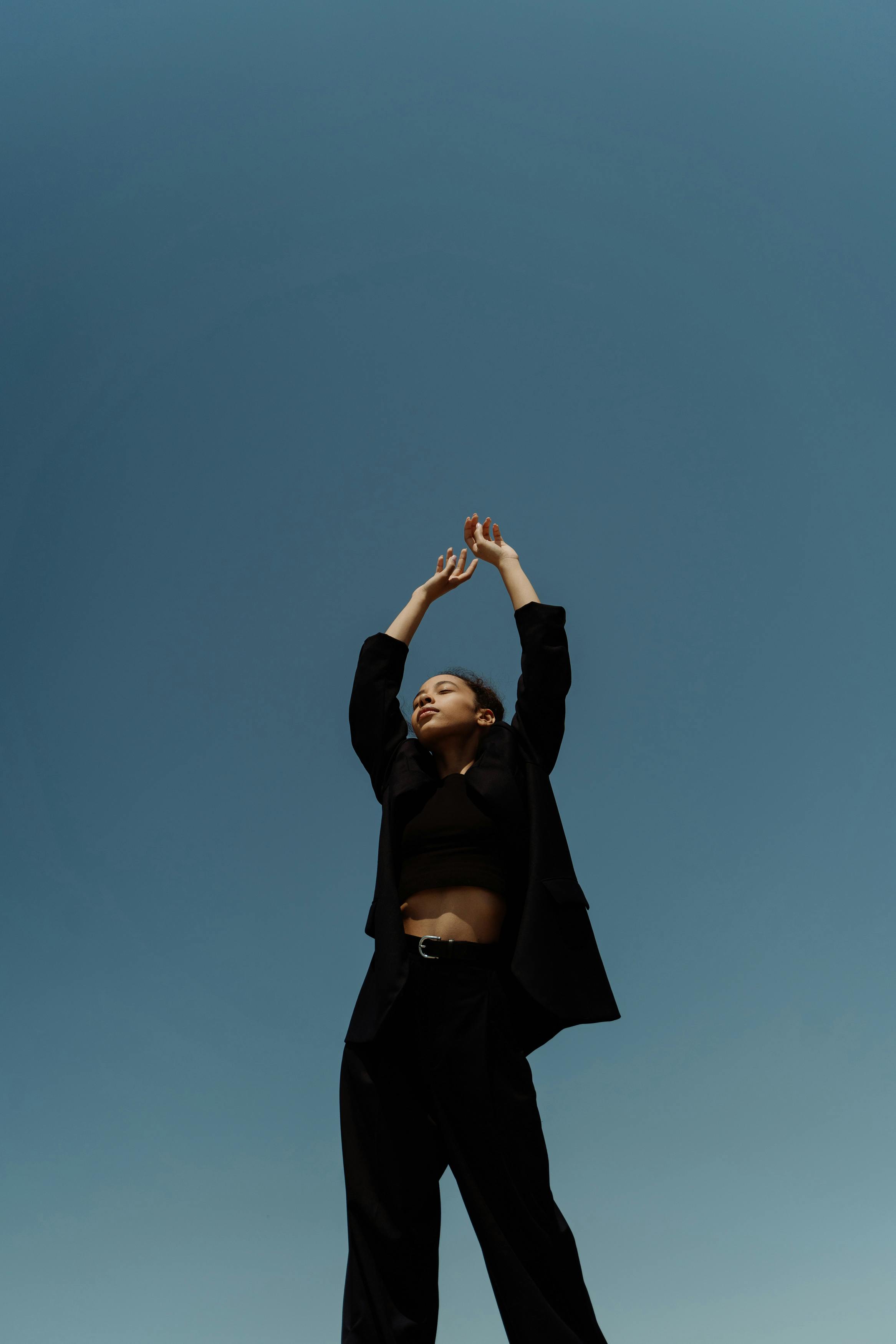 A Low Angle Shot of a Woman in Black Blazer Raising Her Hands · Free ...