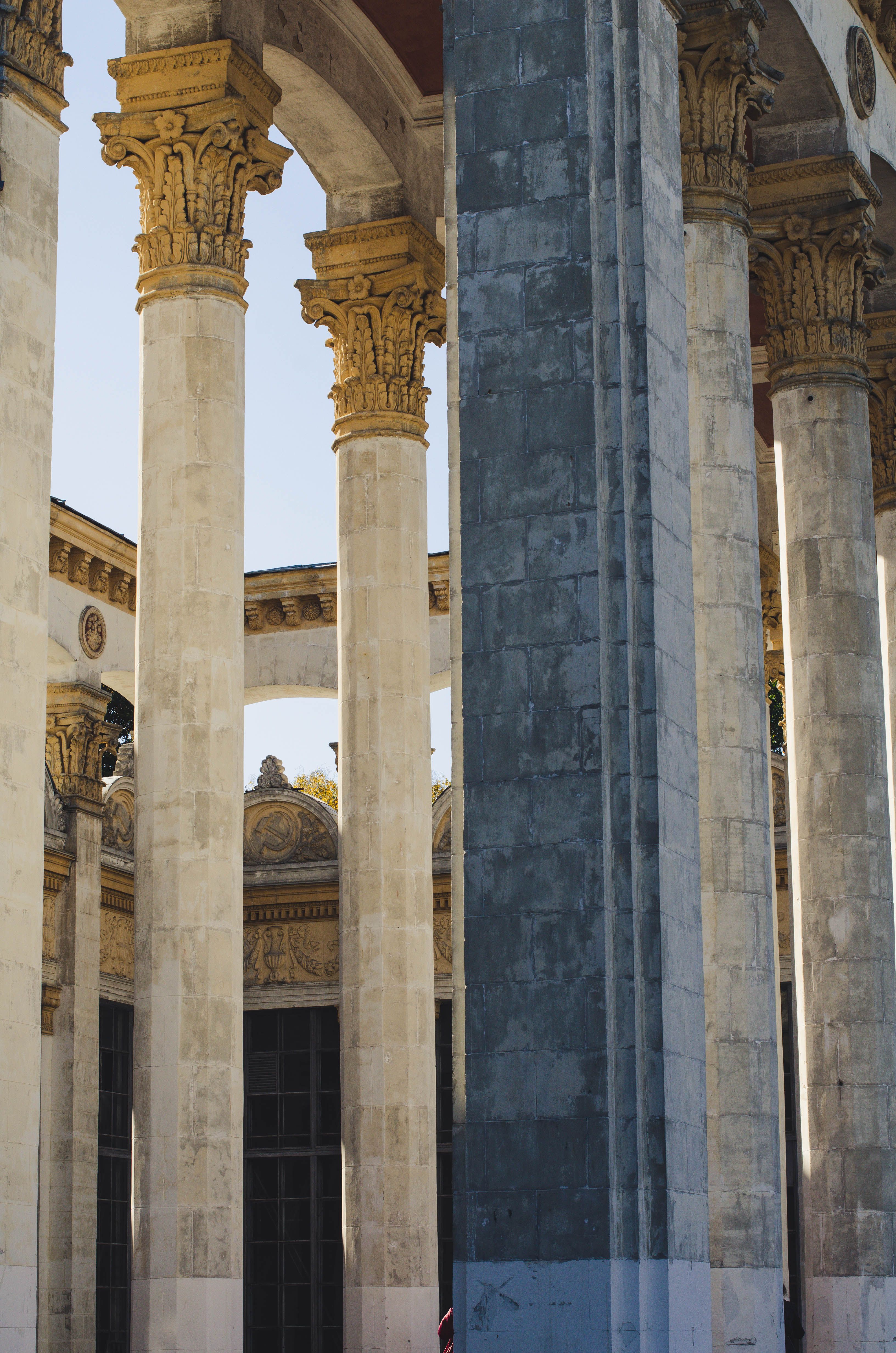 Woman Walking Through Pillars Of A Building · Free Stock Photo