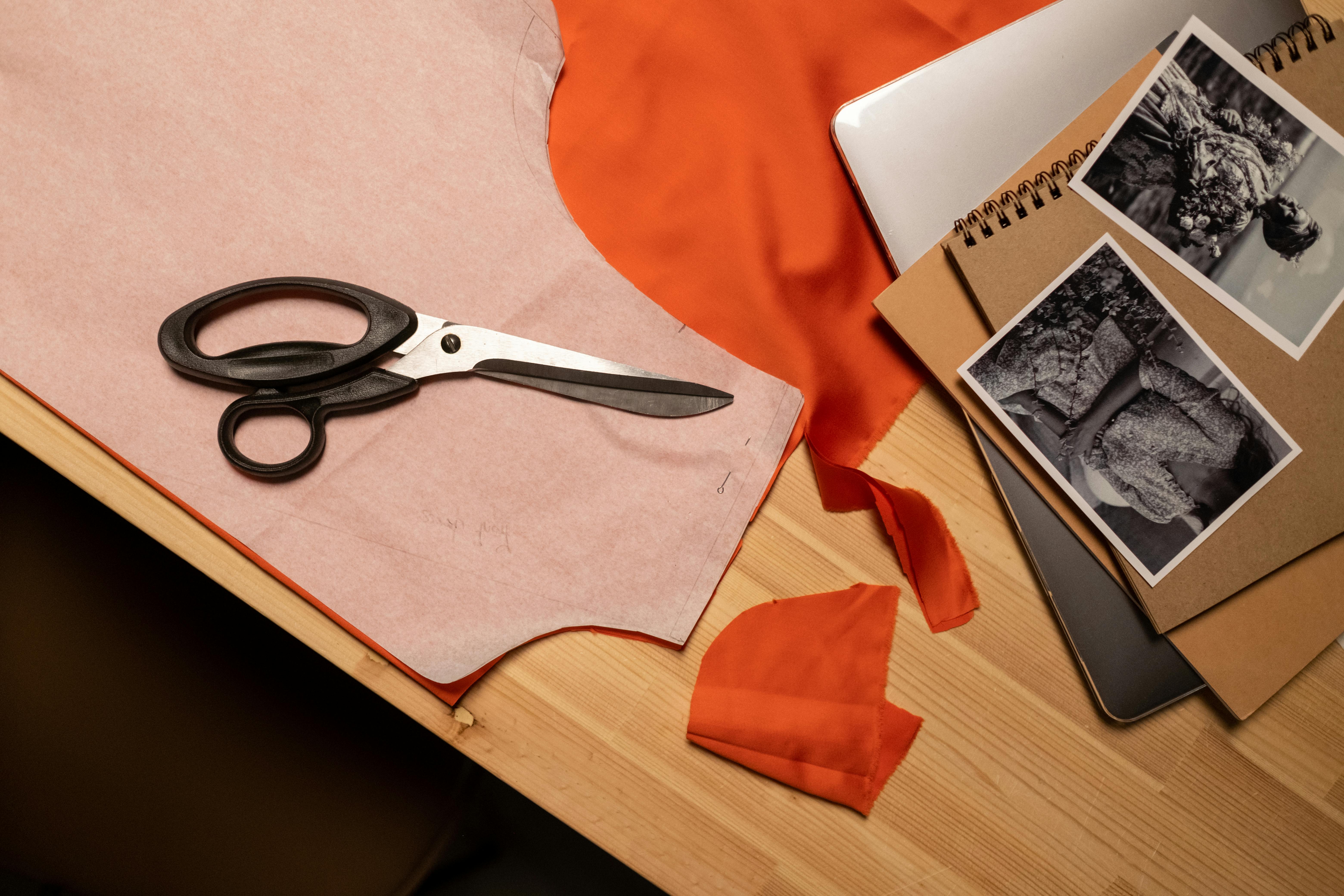 Close-up View of Scissors, Photos and Fabrics on Table · Free Stock Photo