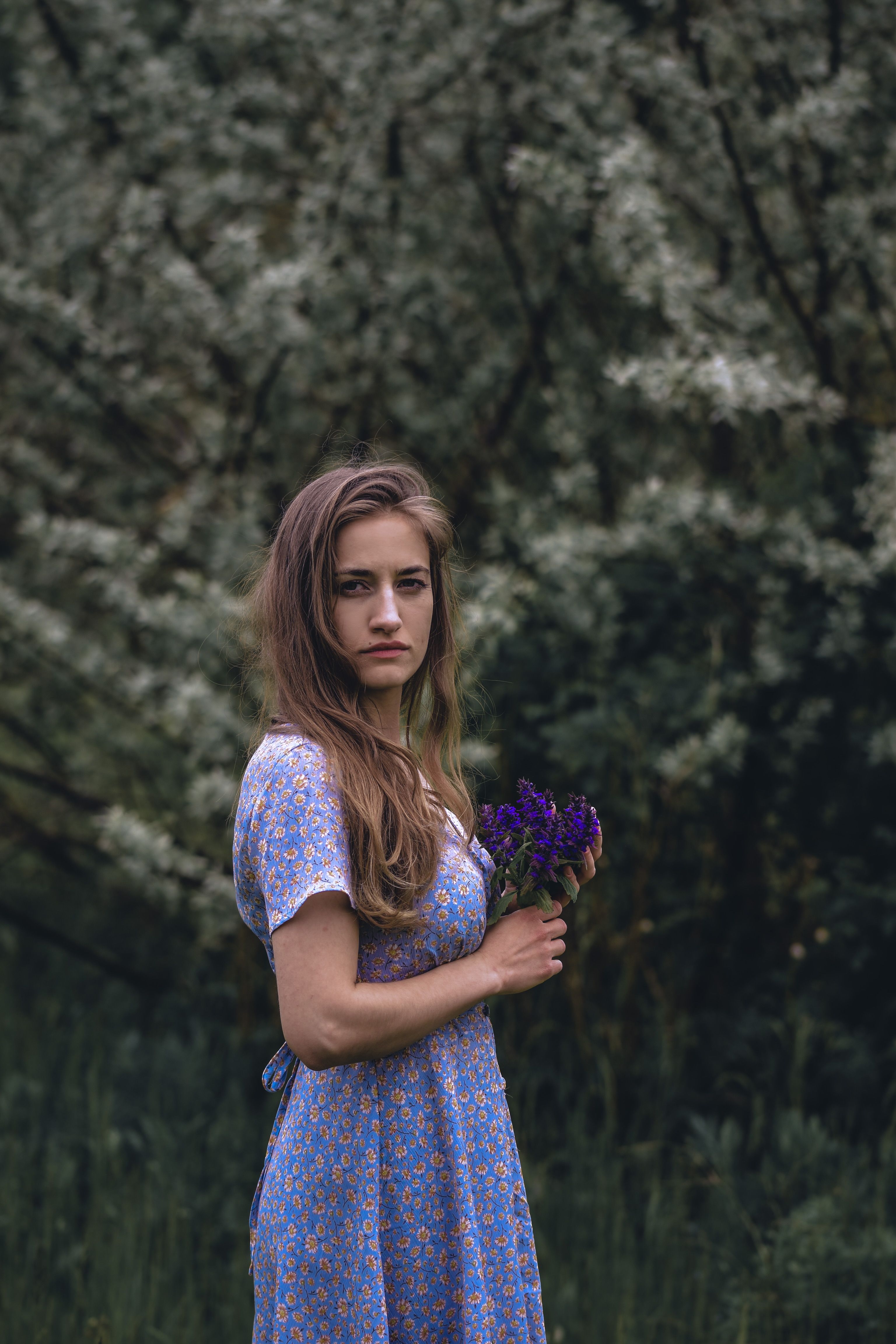 Woman Wearing Floral Dress Throwing a Bunch of Purple Flowers · Free ...