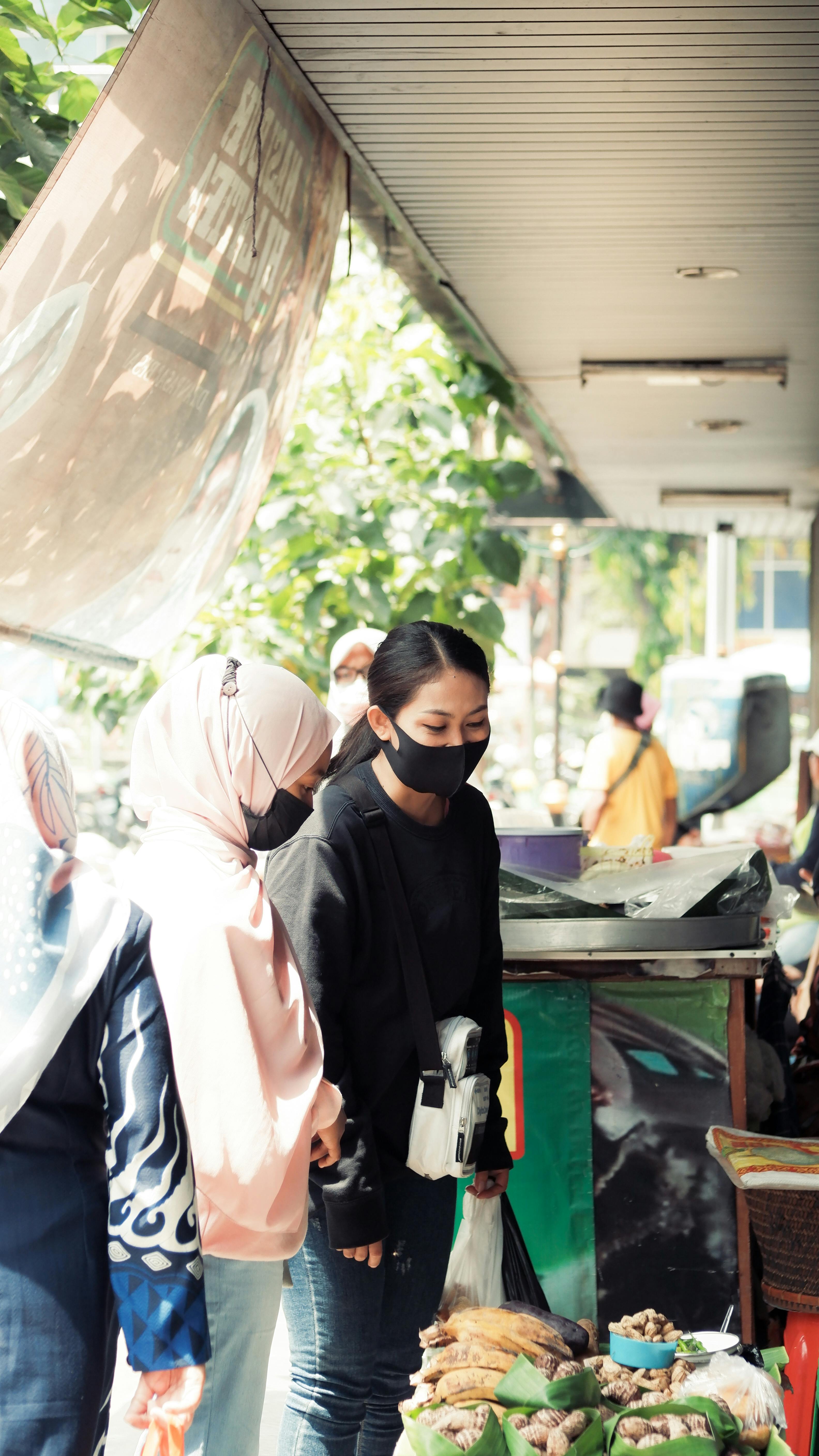 A Woman in Hijab Giving Out a Packed Food · Free Stock Photo