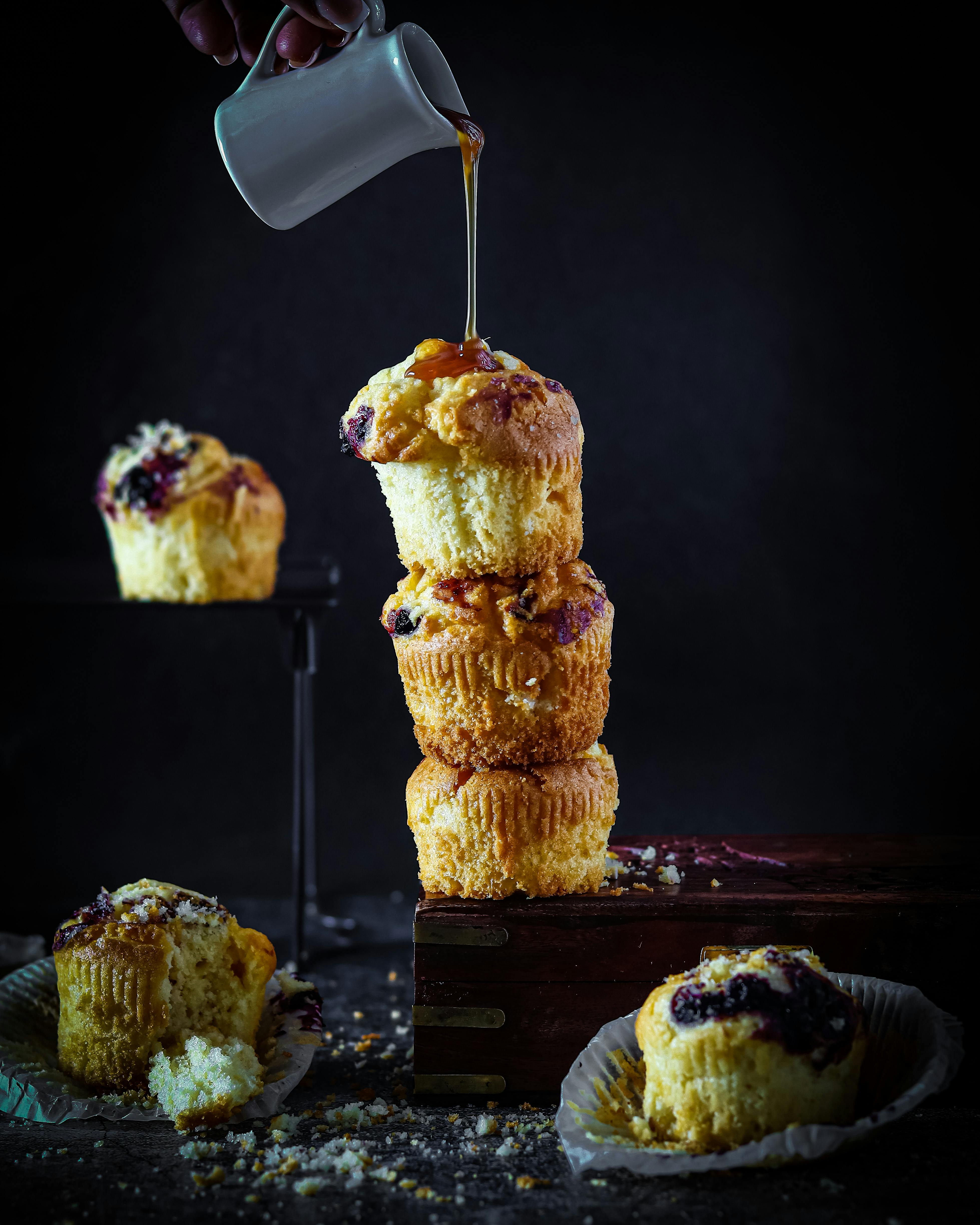 A Person Pouring Syrup on the Top of a Muffin · Free Stock Photo