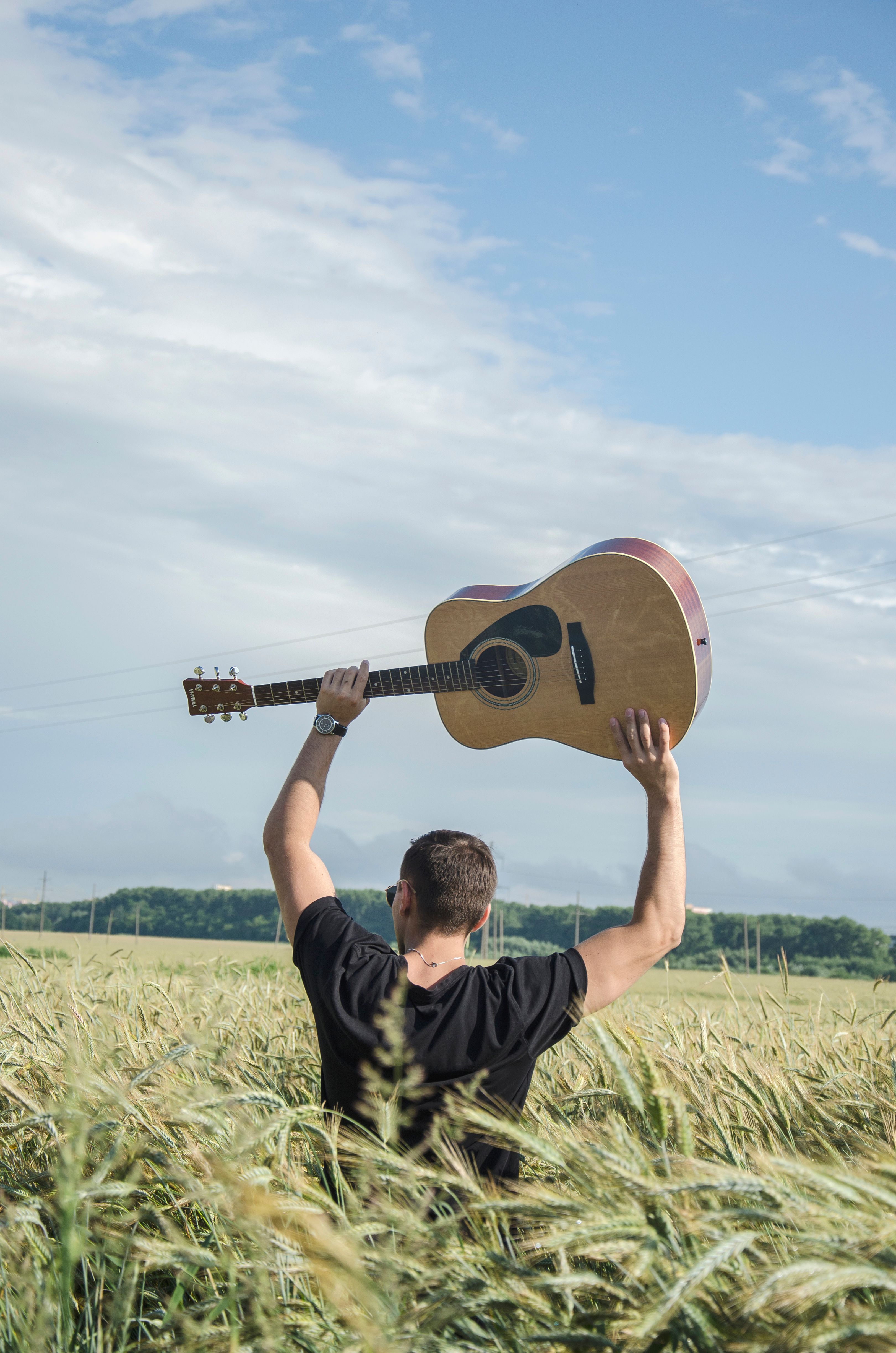 A Man Raising a Guitar · Free Stock Photo