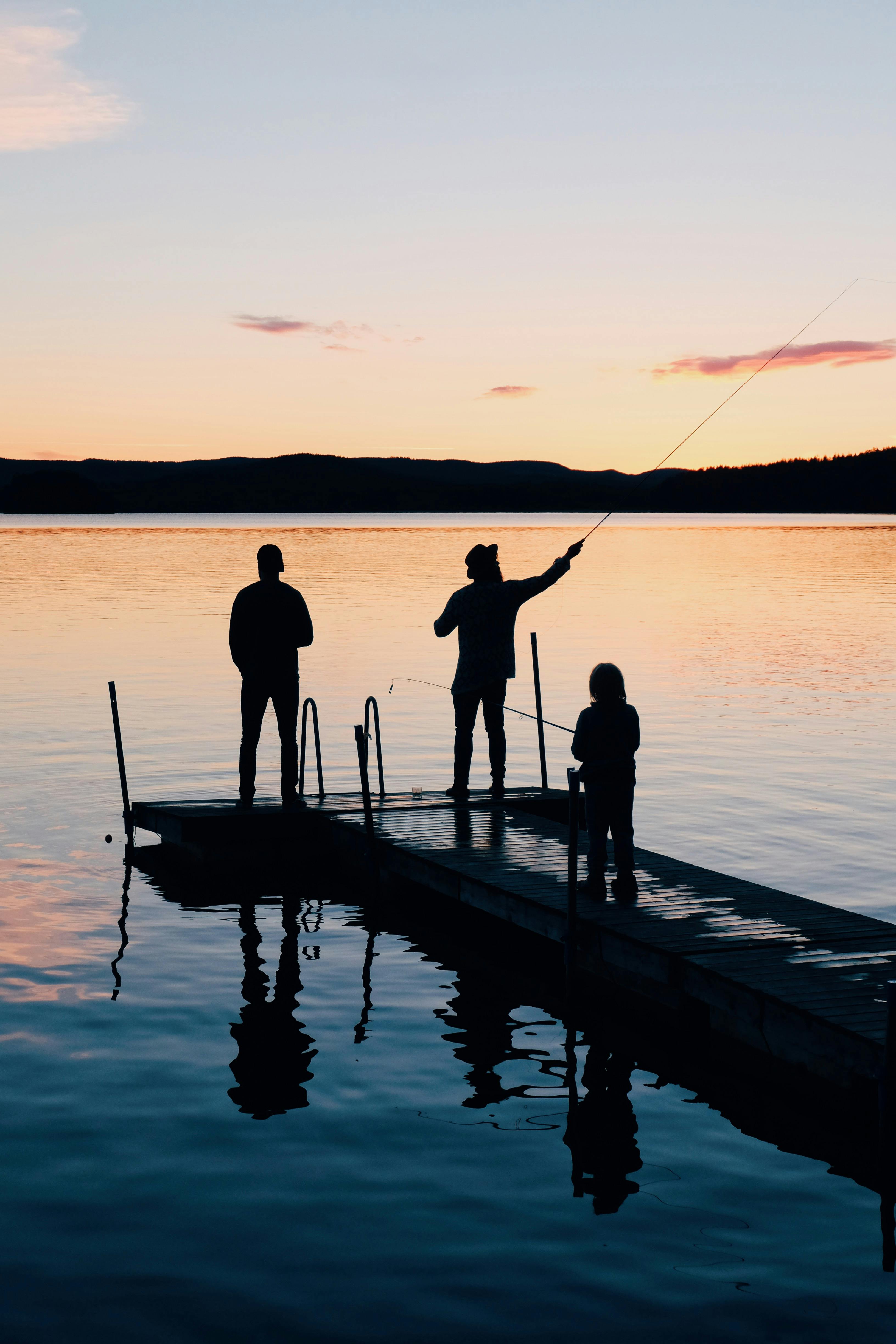 Three People on a Wooden Fishing Docks · Free Stock Photo