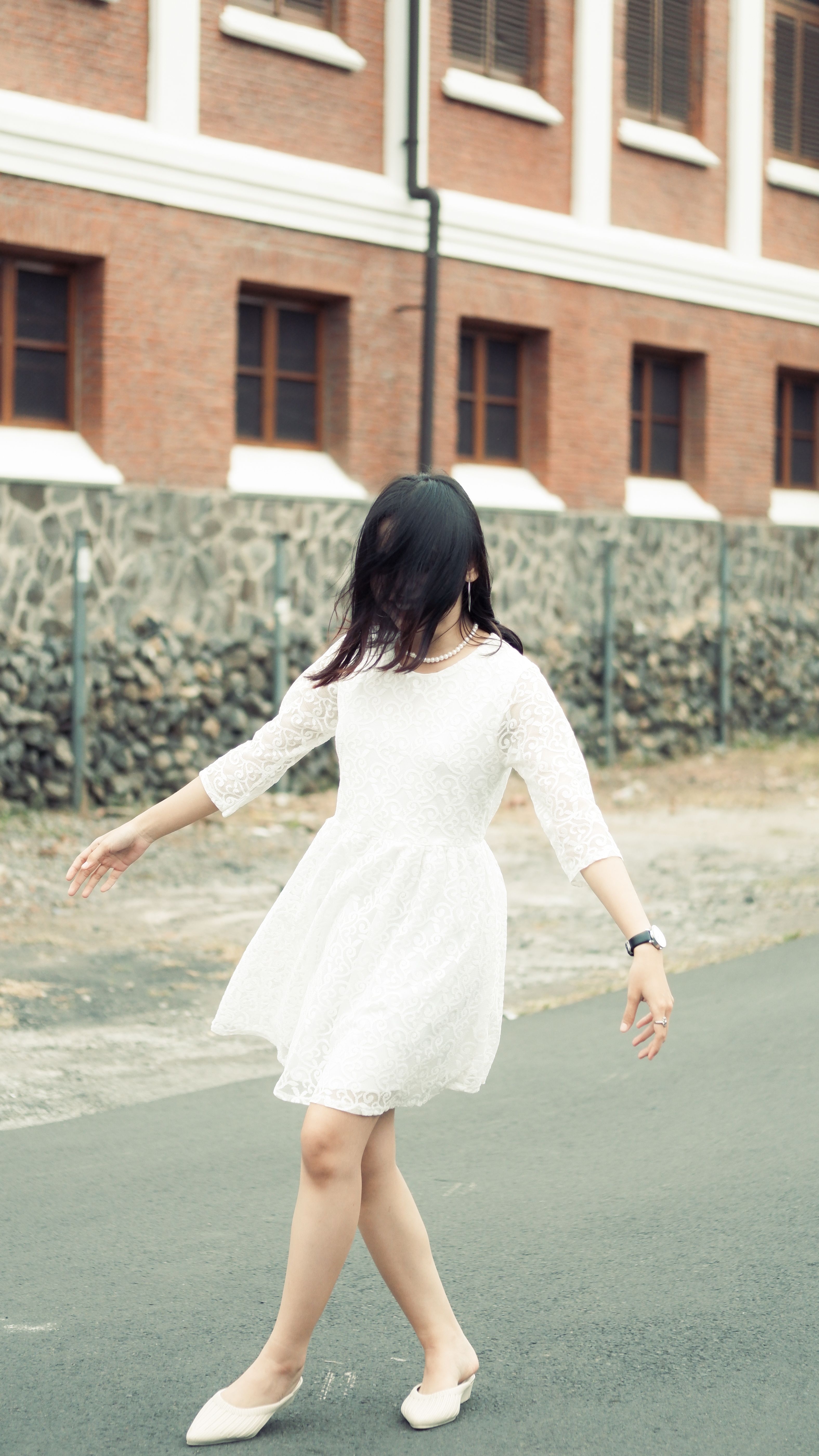 Person in White Dress Walking along Empty Street · Free Stock Photo