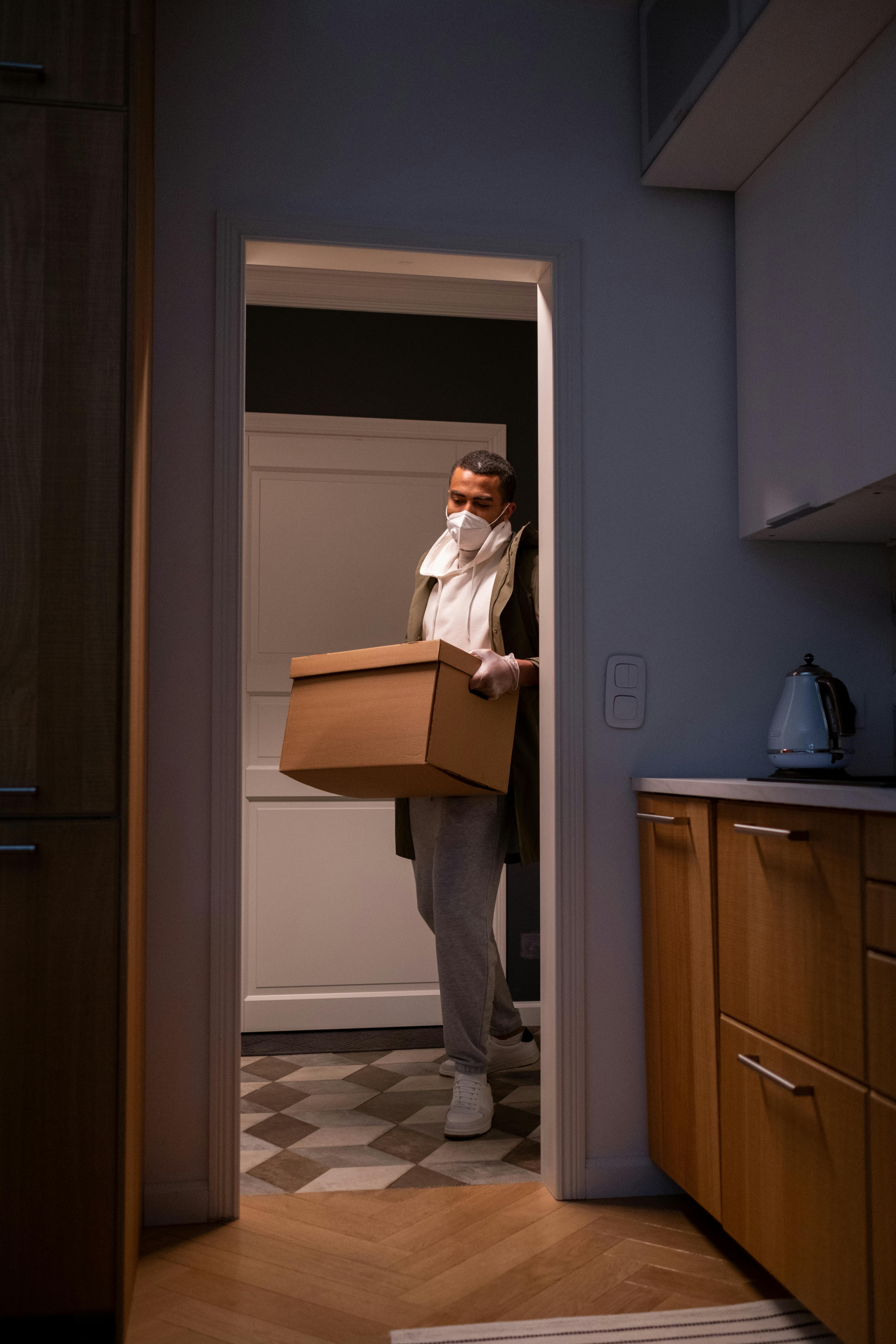 Man Entering Kitchen with Box · Free Stock Photo