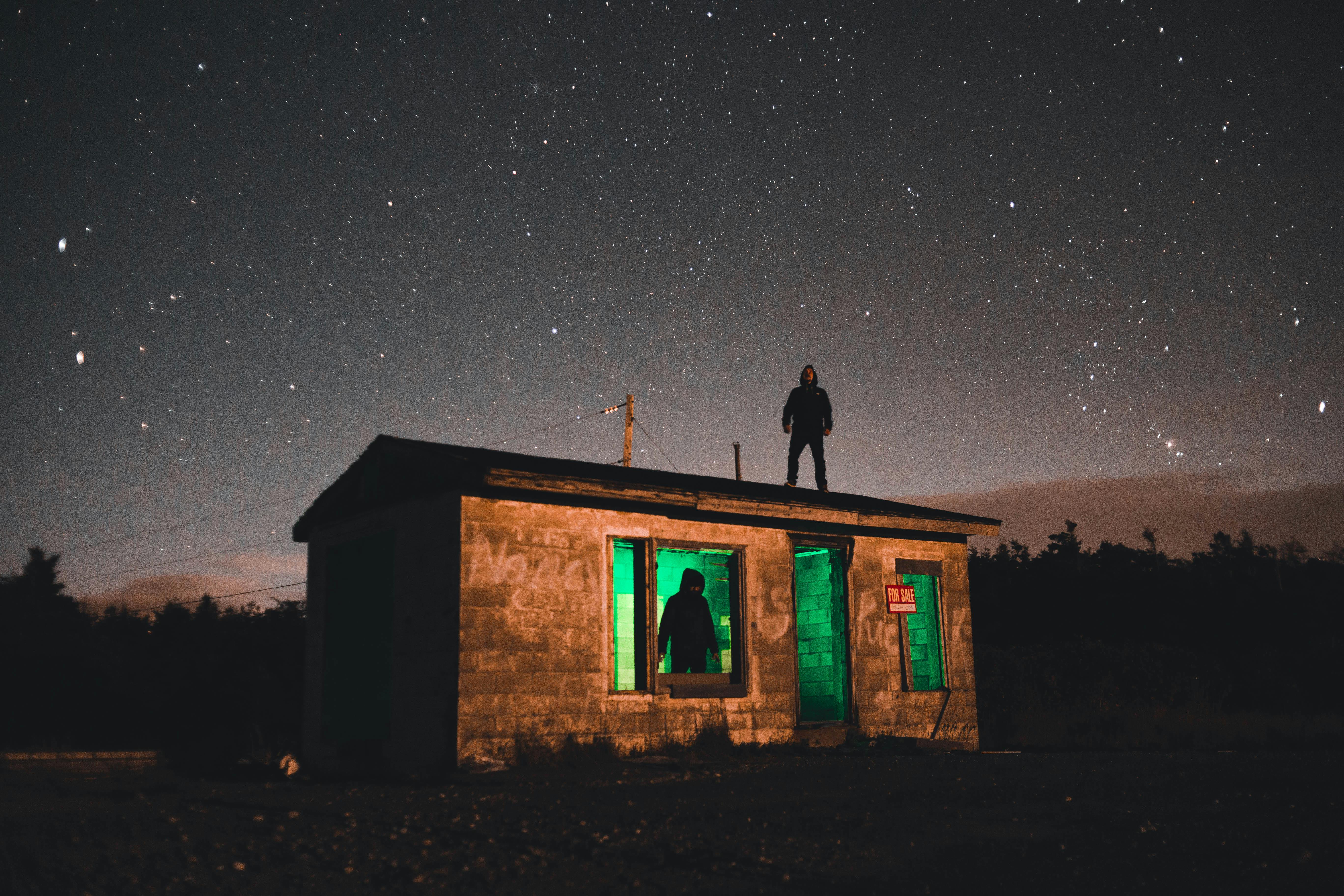 Small Building at Night with Person on Roof · Free Stock Photo