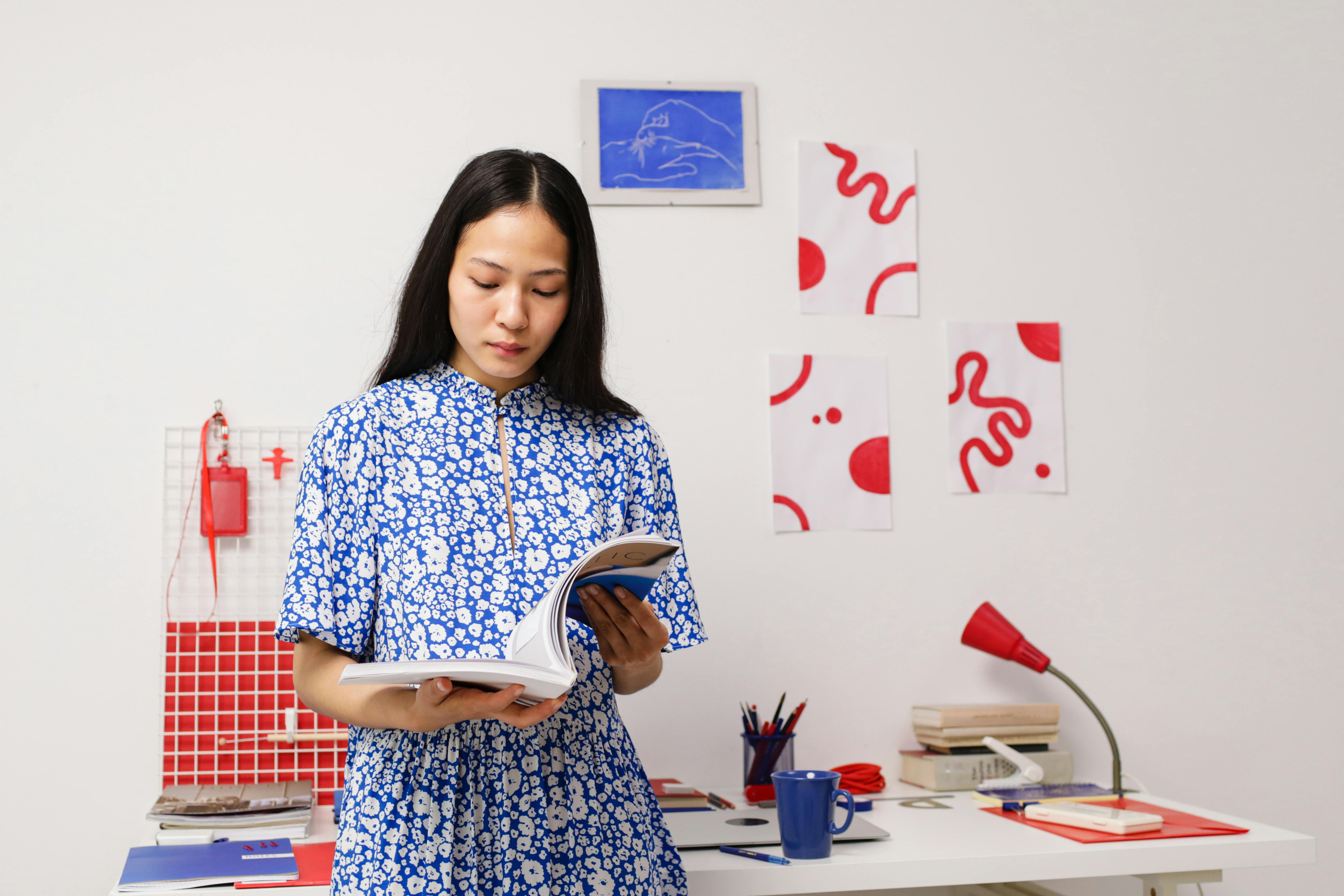 Woman in Blue Dress Reading Magazine in Home Office · Free Stock Photo