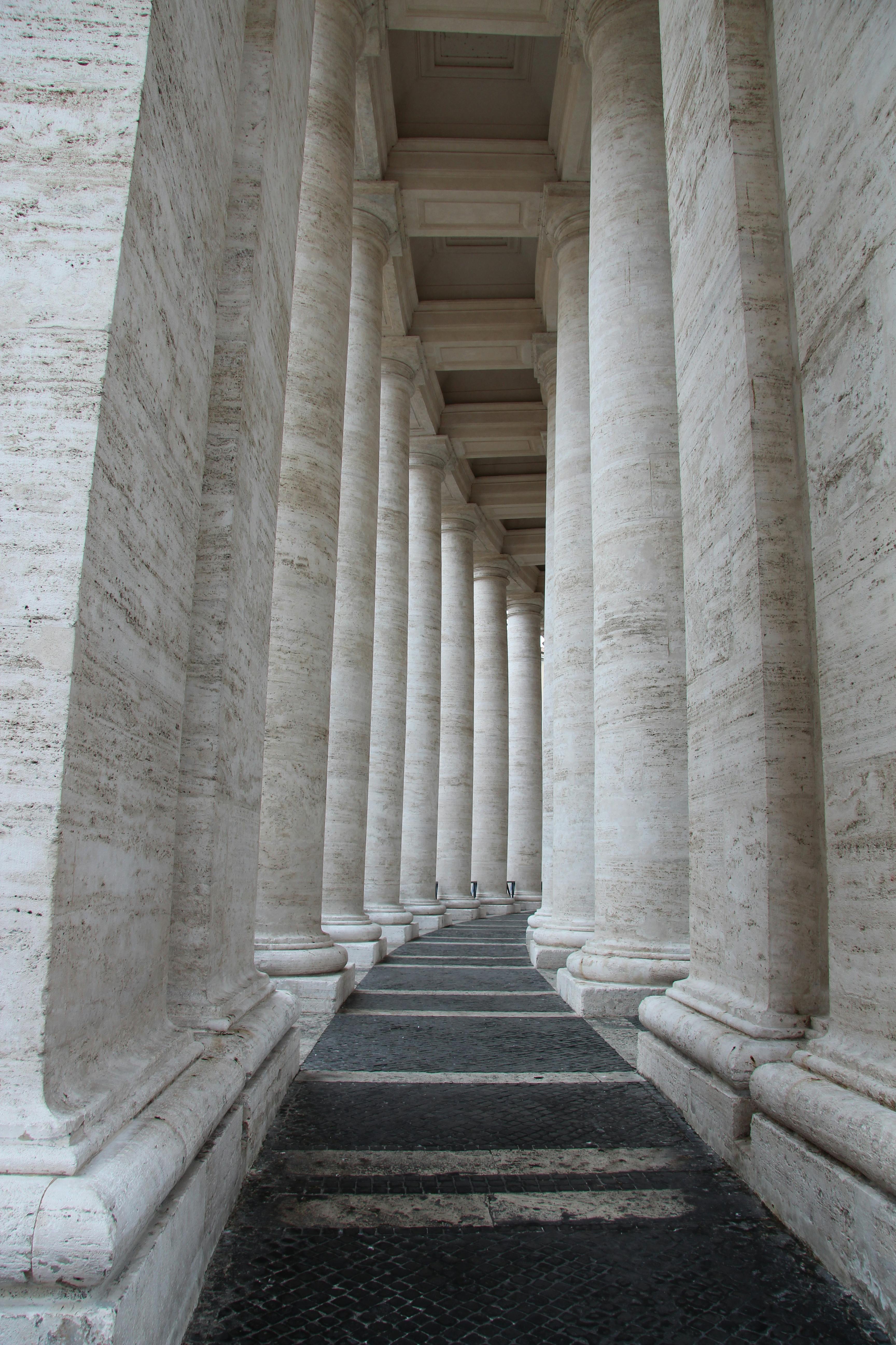 A Narrow Hallway Between Series of Columns · Free Stock Photo